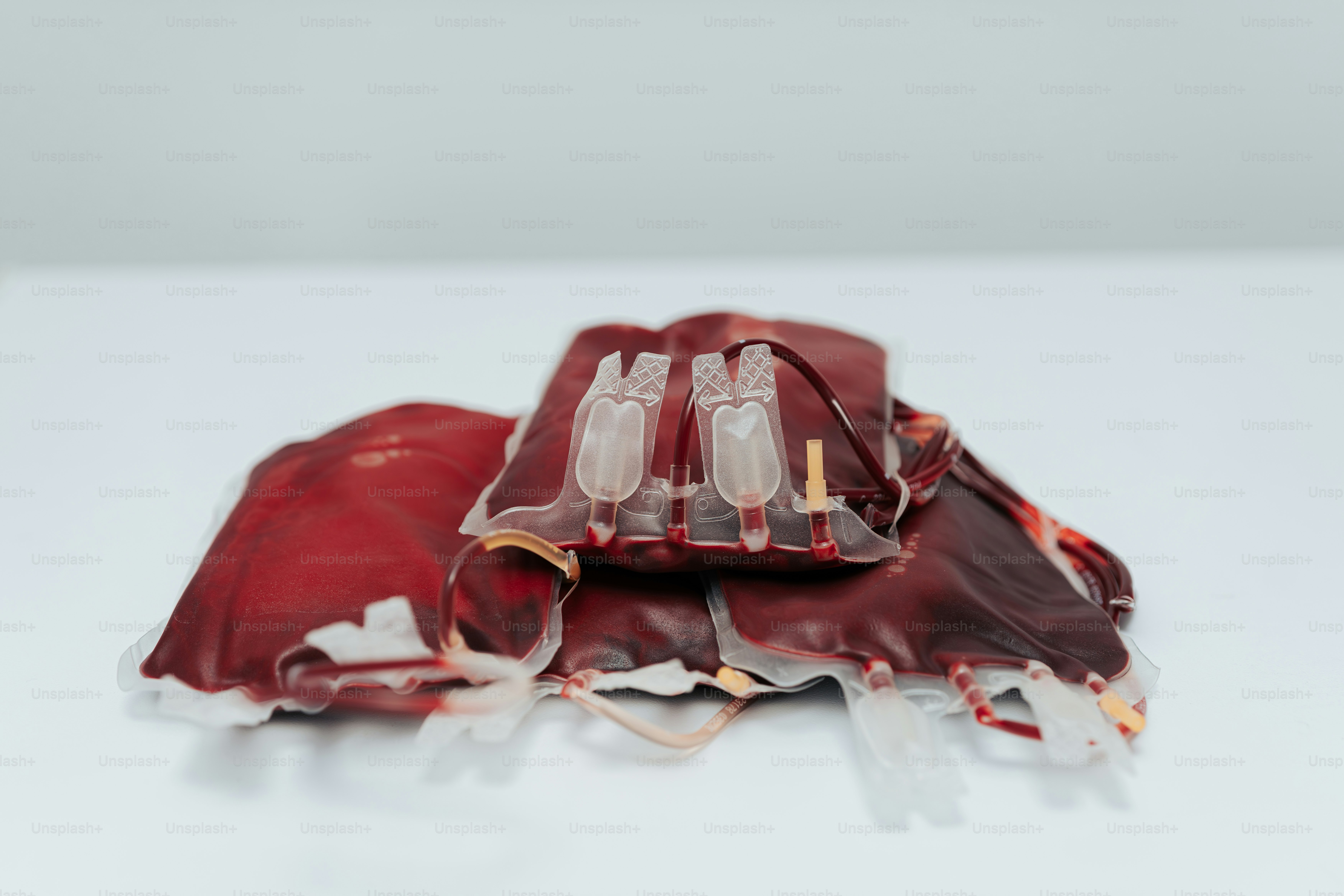 A group of plastic bags filled with blood on top of a white table photo ...