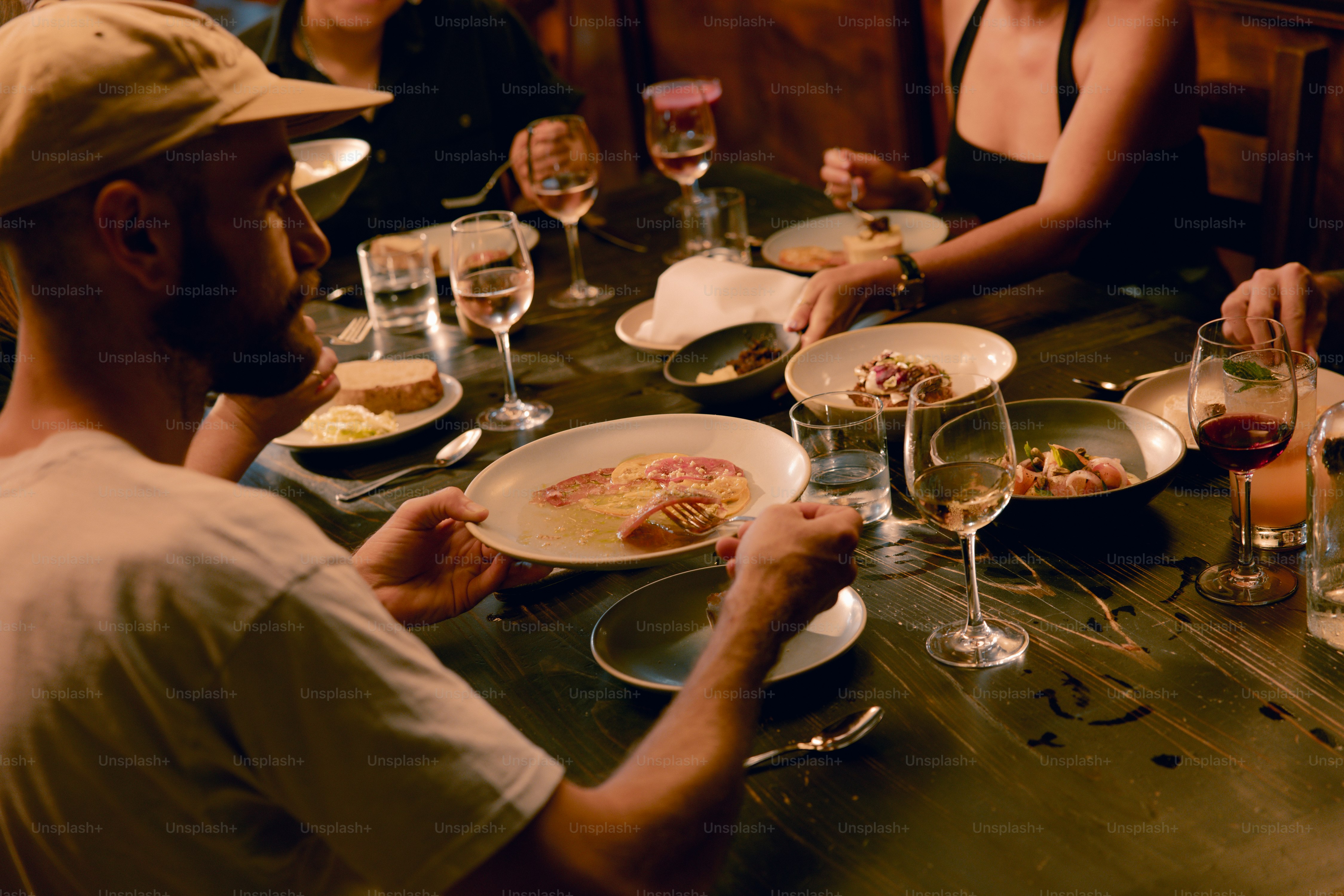 Un groupe de personnes assises autour d’une table en train de manger ...