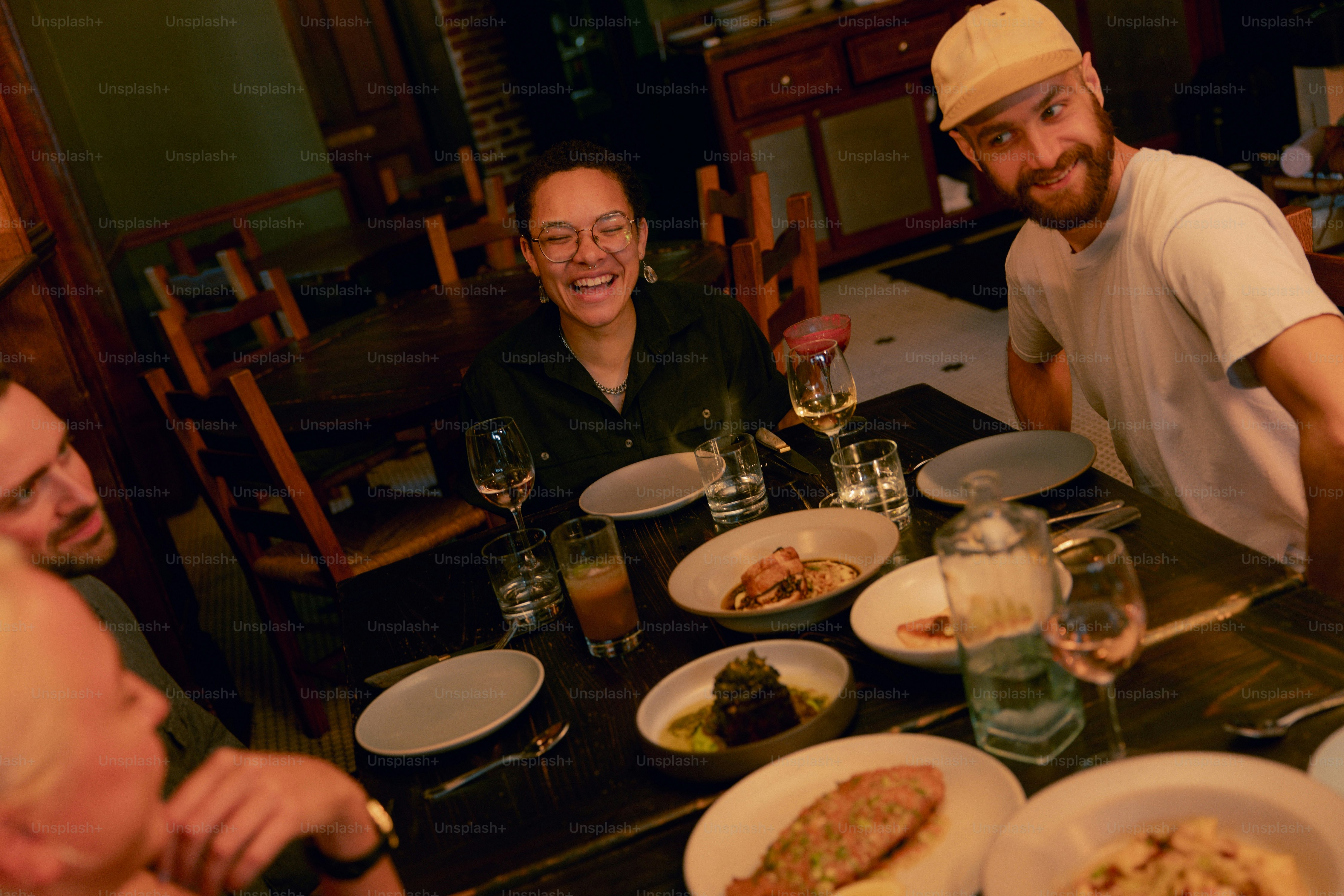 Un groupe de personnes assises autour d’une table avec des assiettes de ...