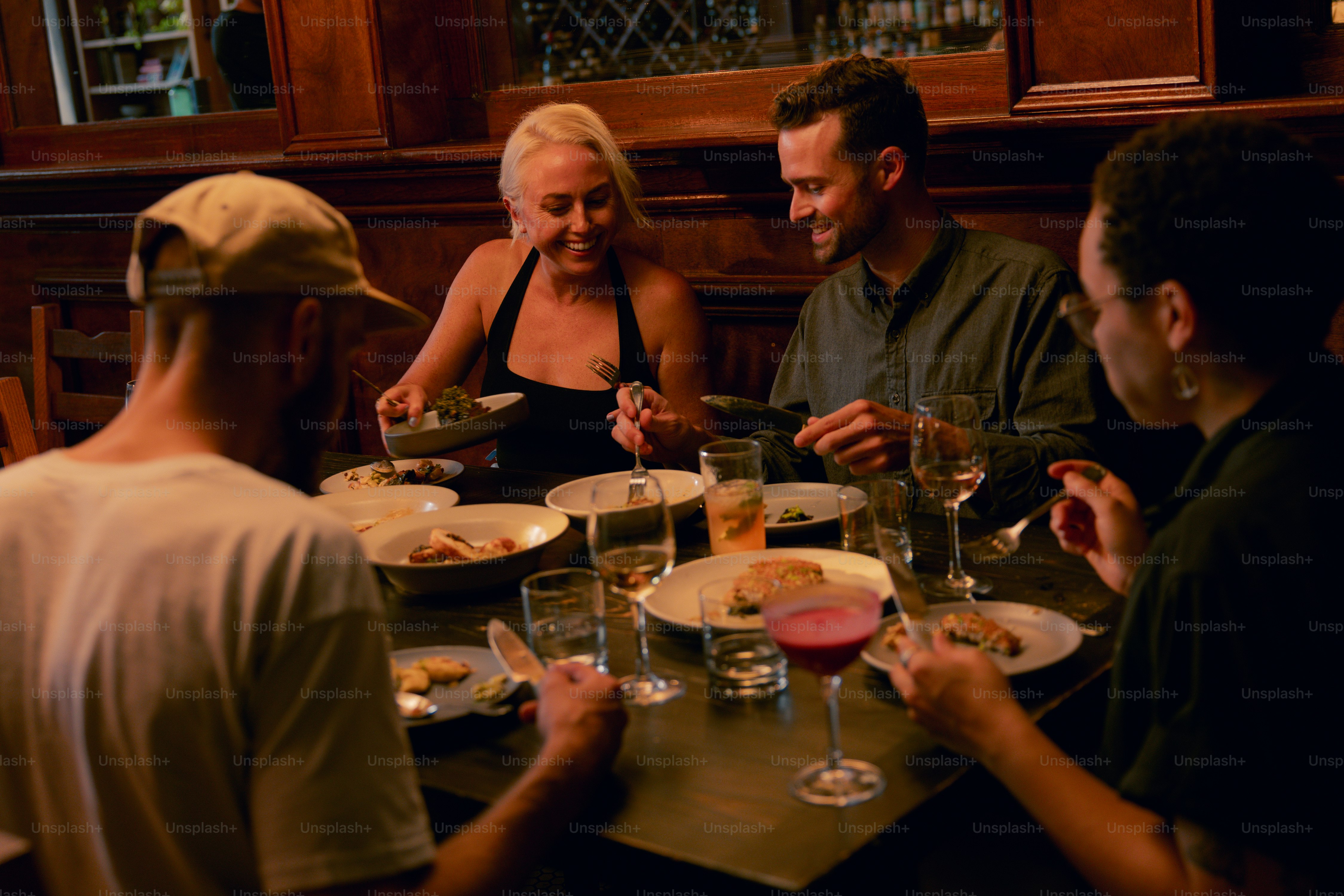 Un groupe de personnes assises autour d’une table en train de manger ...