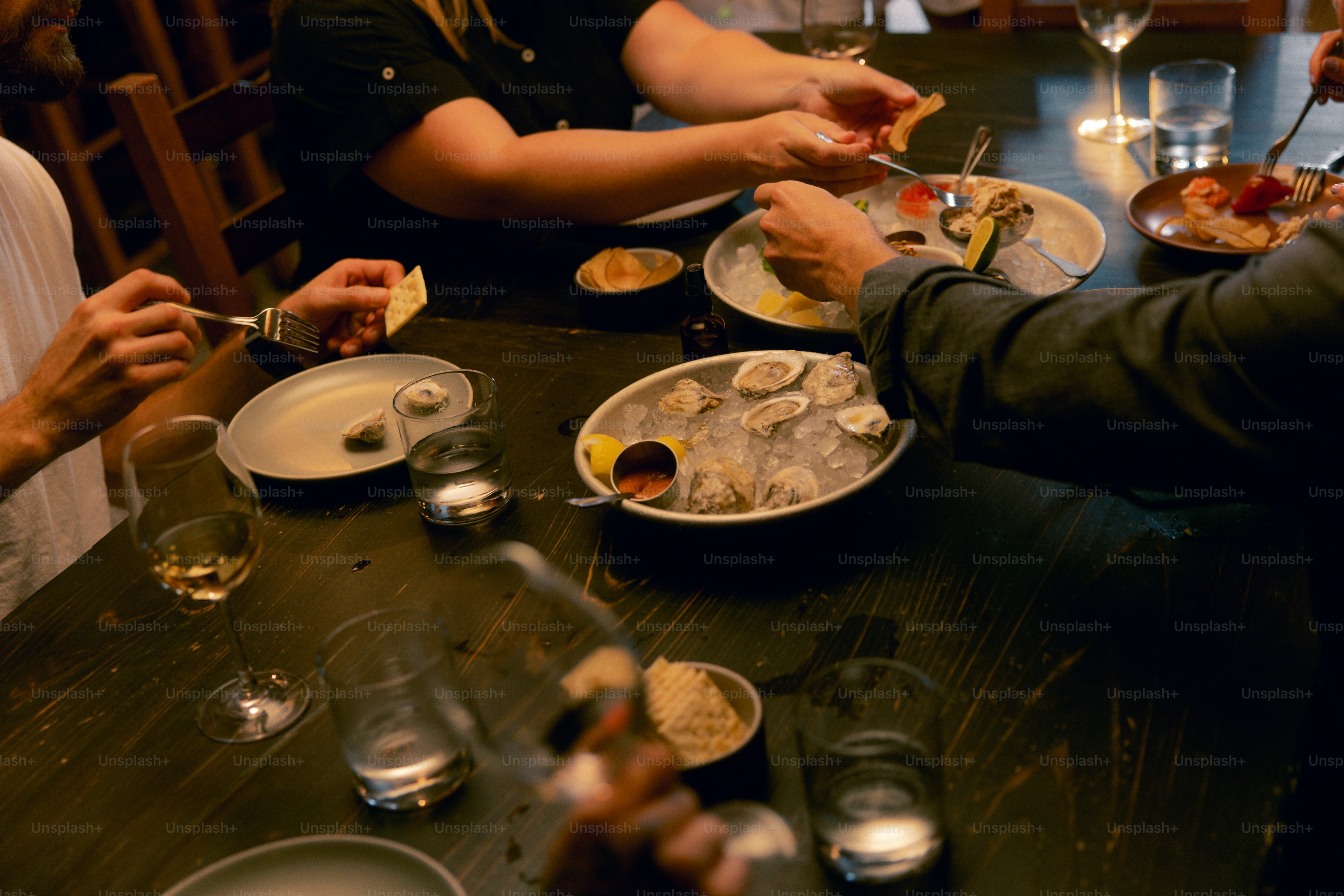A group of people sitting around a table eating food photo – Go for a ...