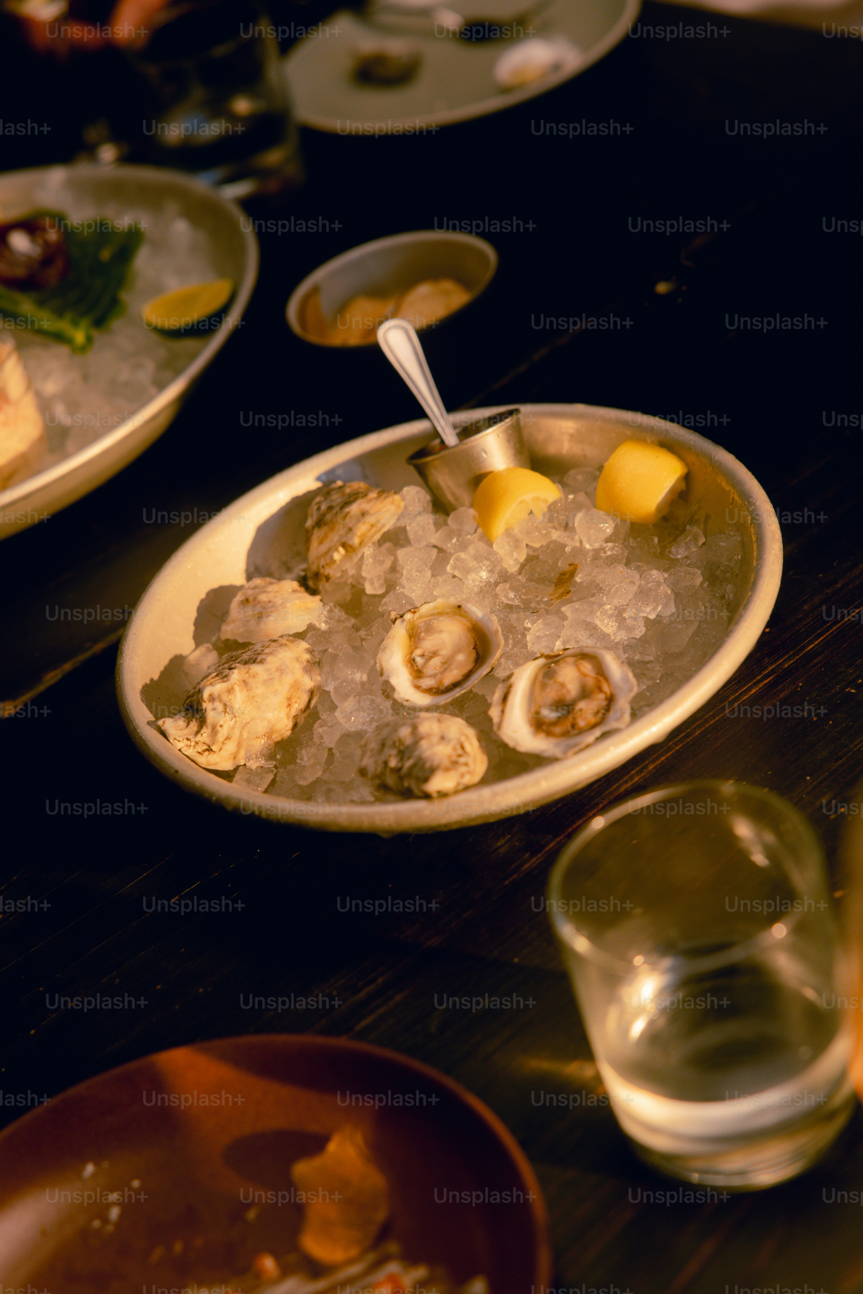 A table with plates of food and a bottle of water photo – Restaurant ...