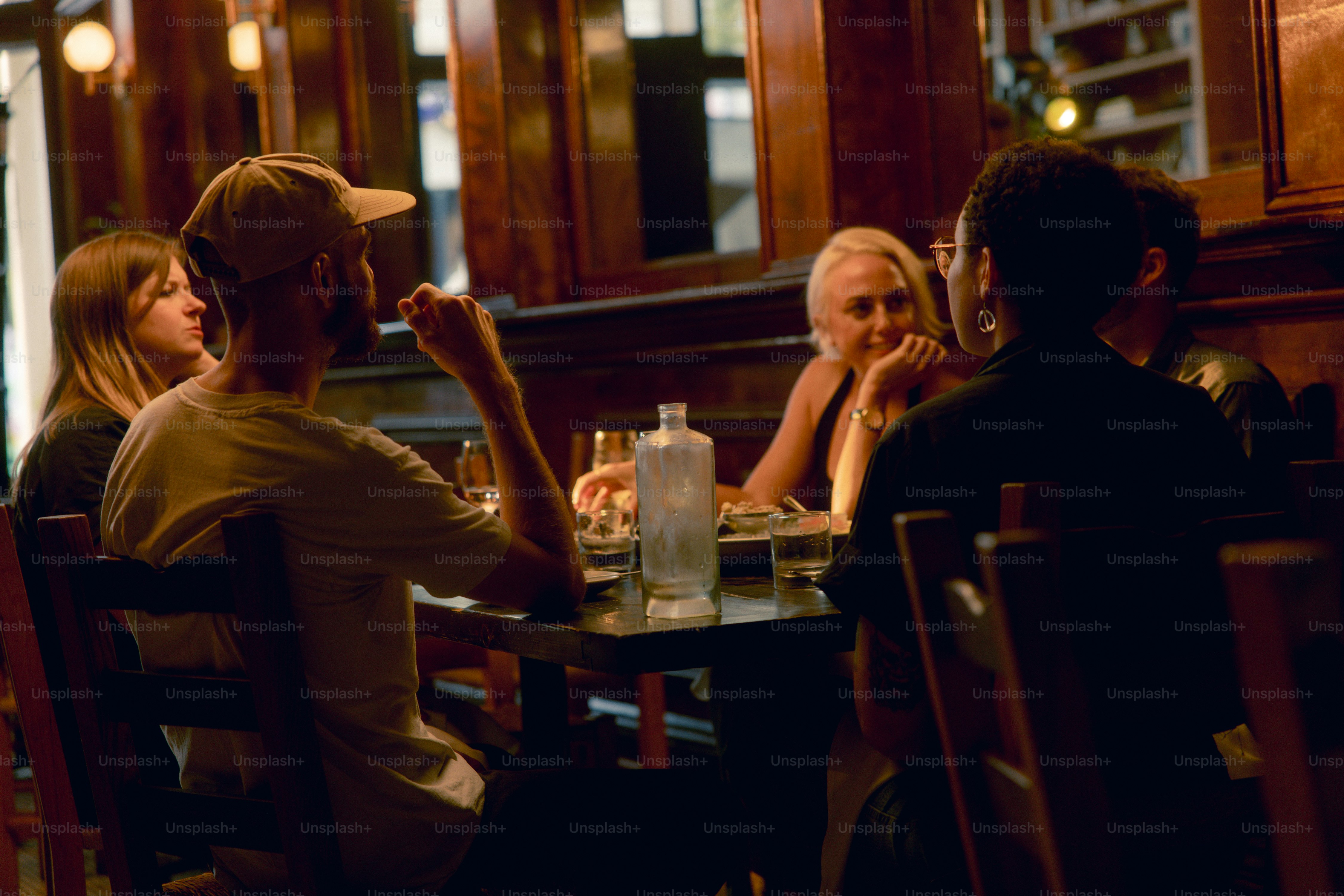 A group of people sitting at a table in a restaurant photo – Dinner ...