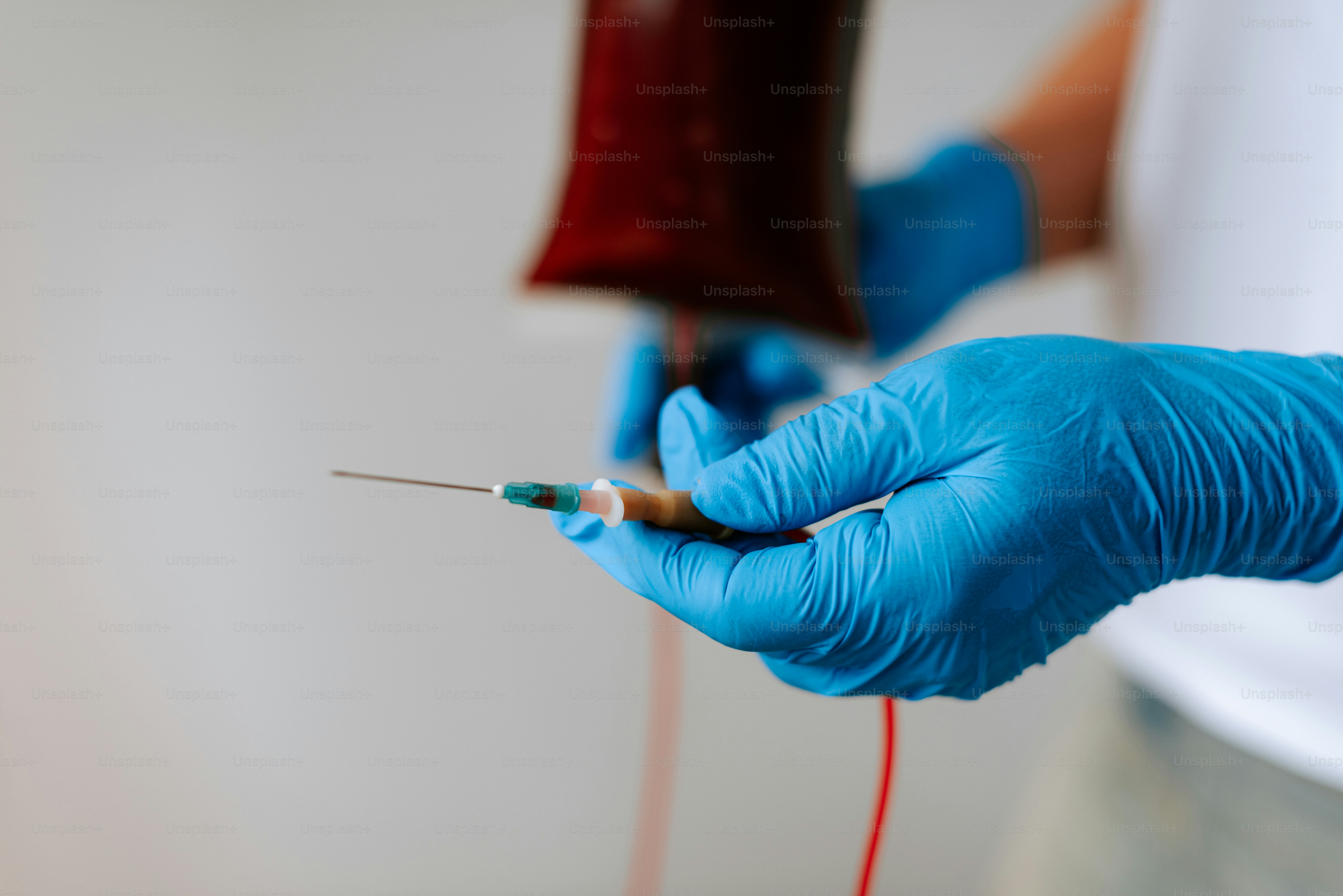 A person in blue gloves is holding a needle photo – Blood Image on Unsplash