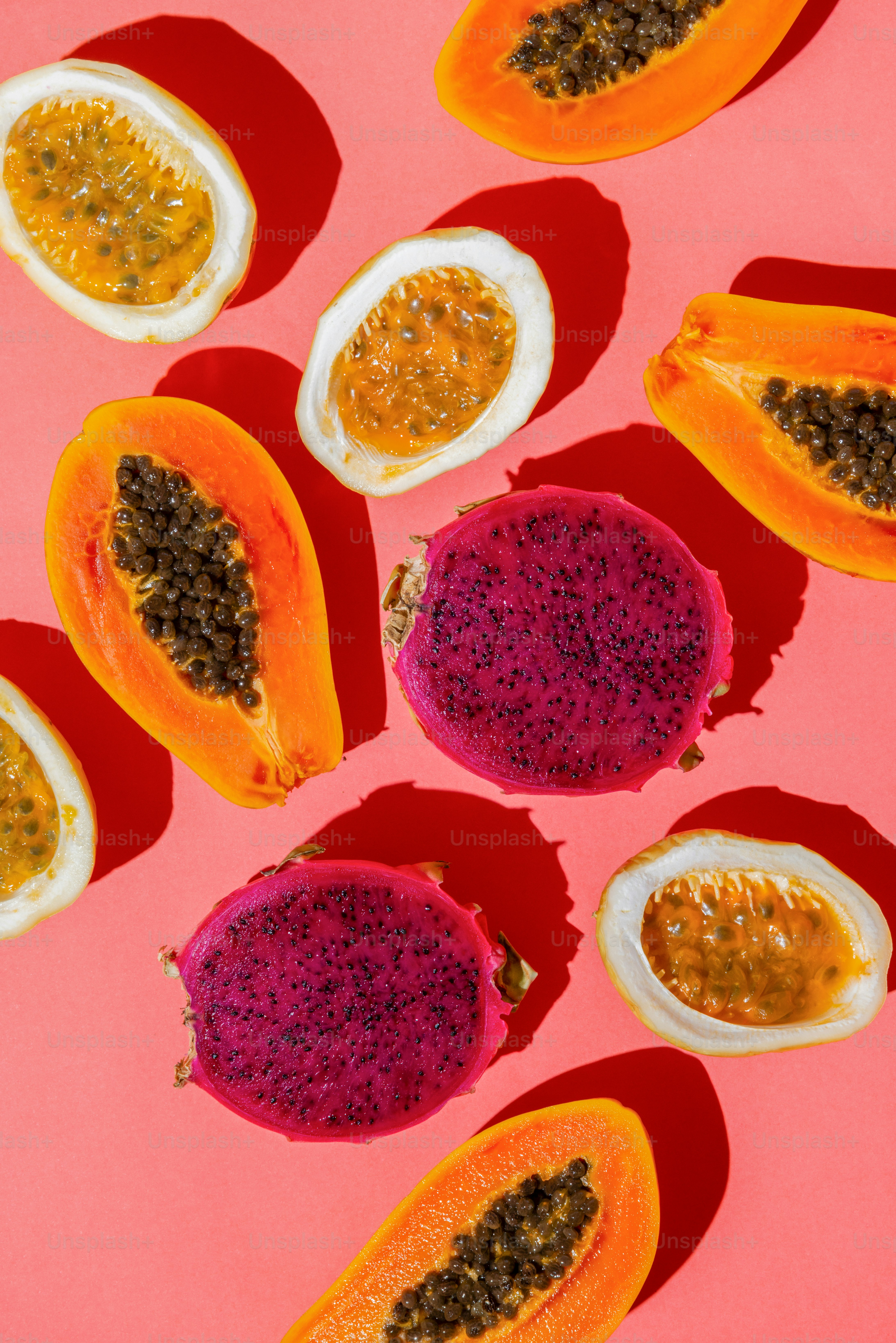 A group of cut up fruit sitting on top of a pink surface photo ...