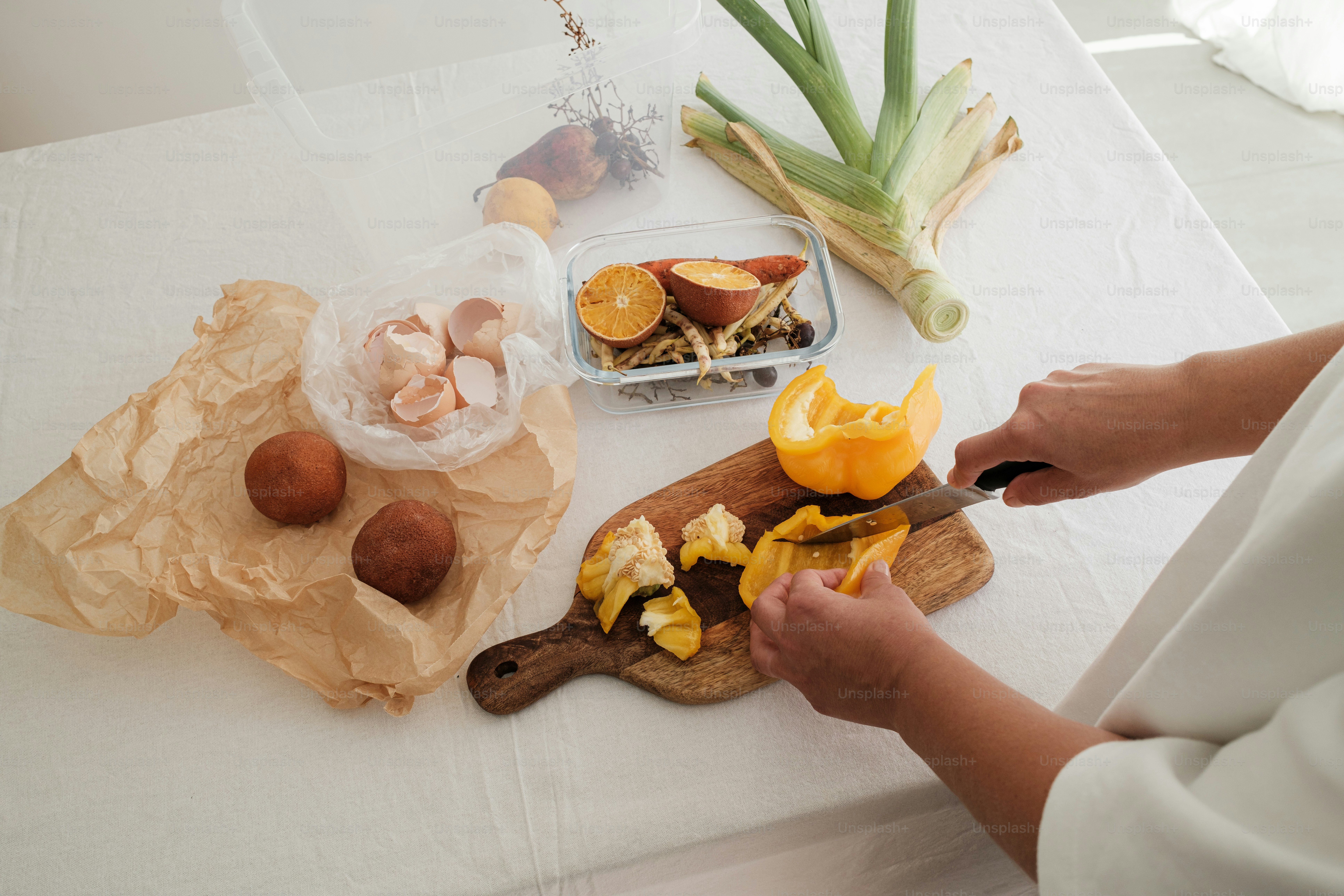 A person cutting up food on a cutting board photo – Vegetable peelings ...