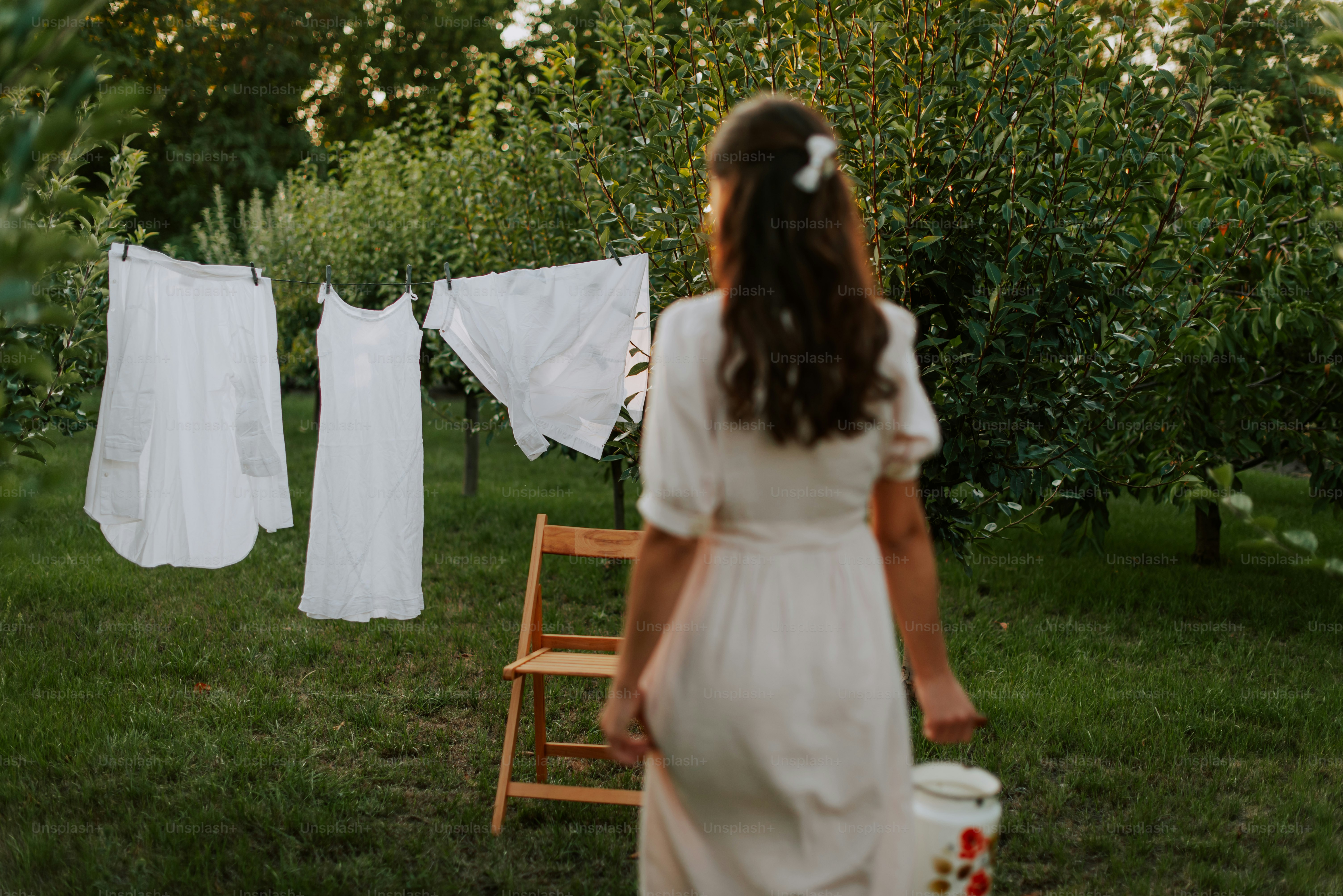 A woman in a white dress holding a bucket photo – Demure Image on Unsplash