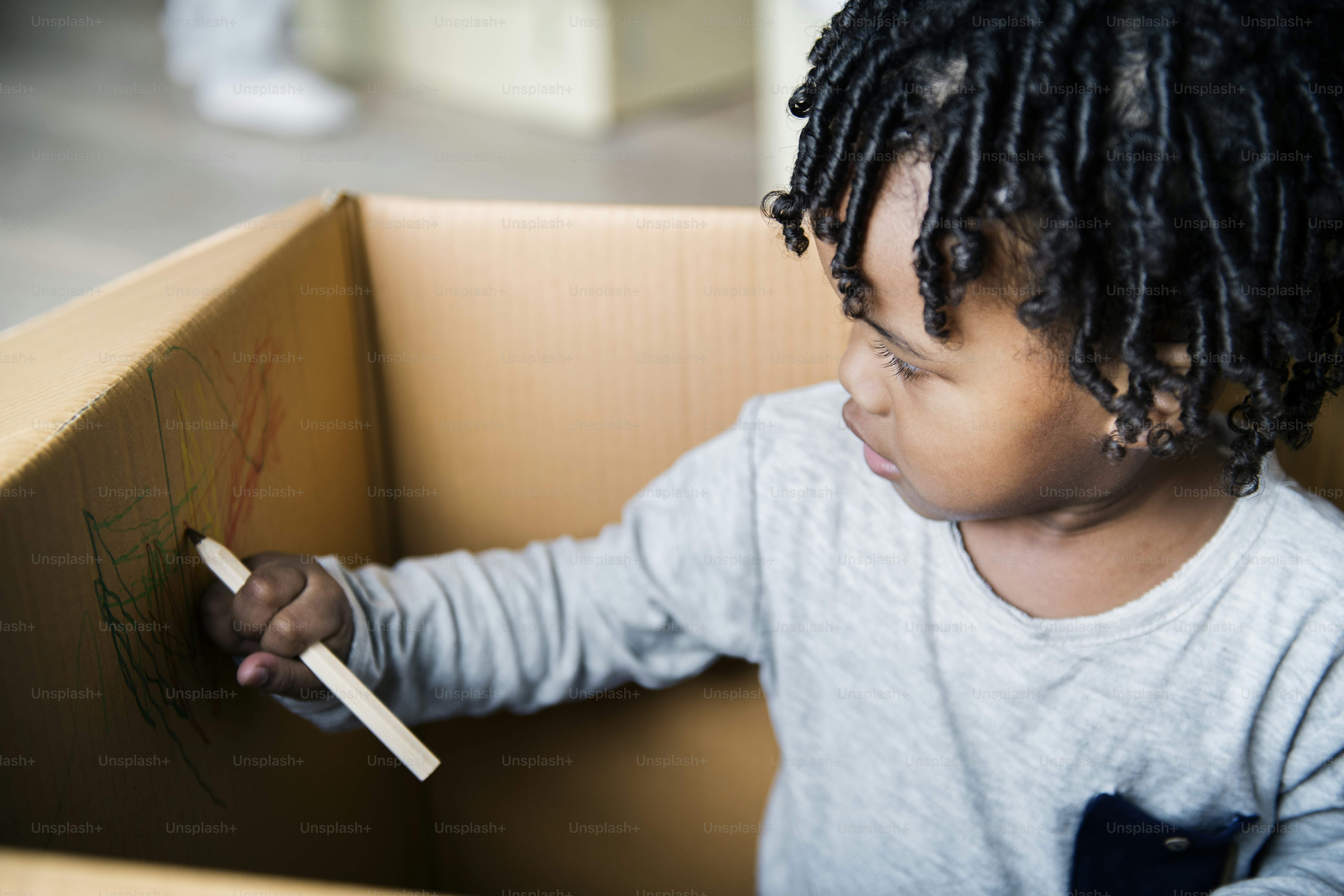 Young black boy drawing in a box photo – Imagination Image on Unsplash