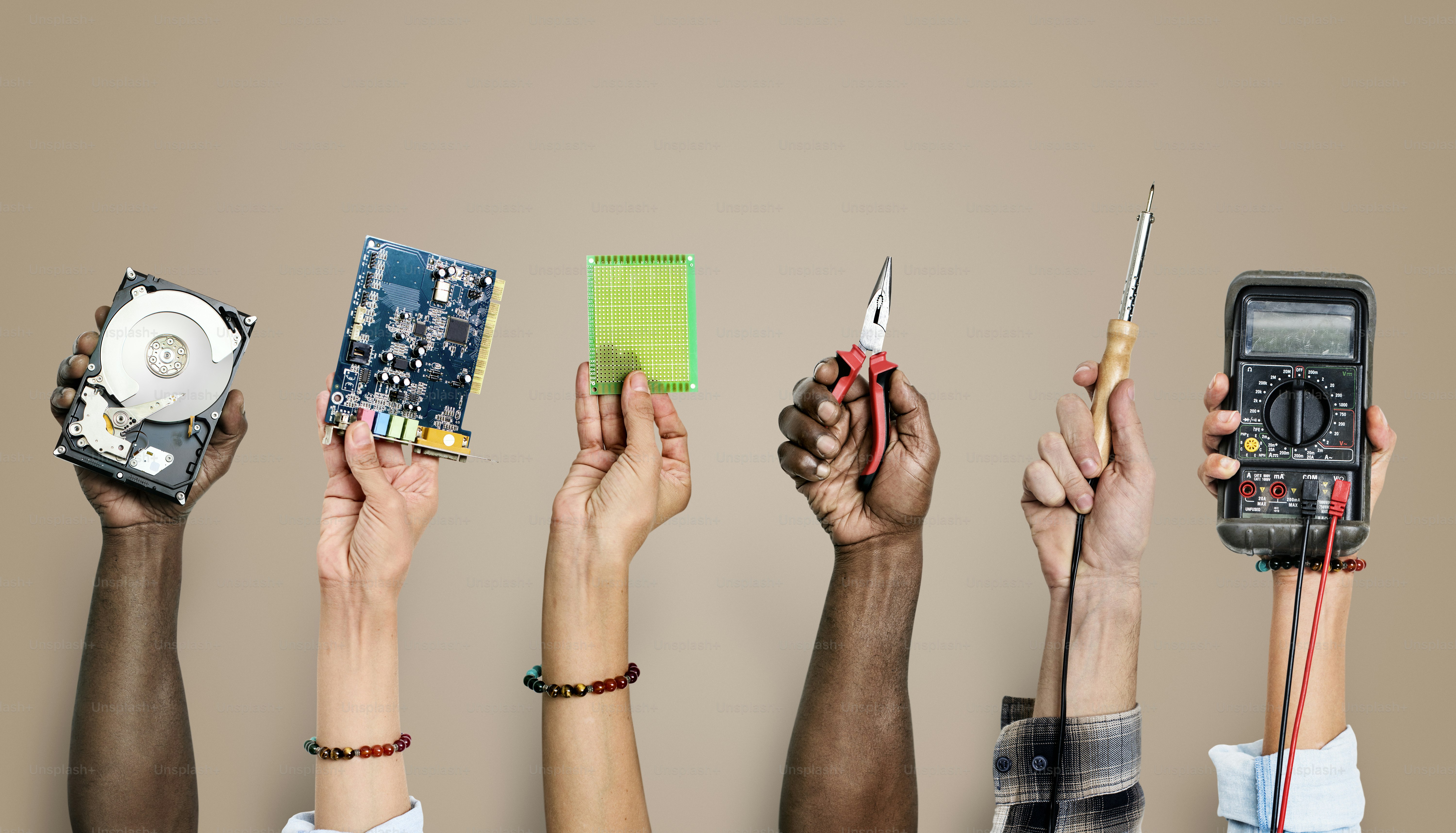 Group of hands holding computer electronics parts isolated on white ...