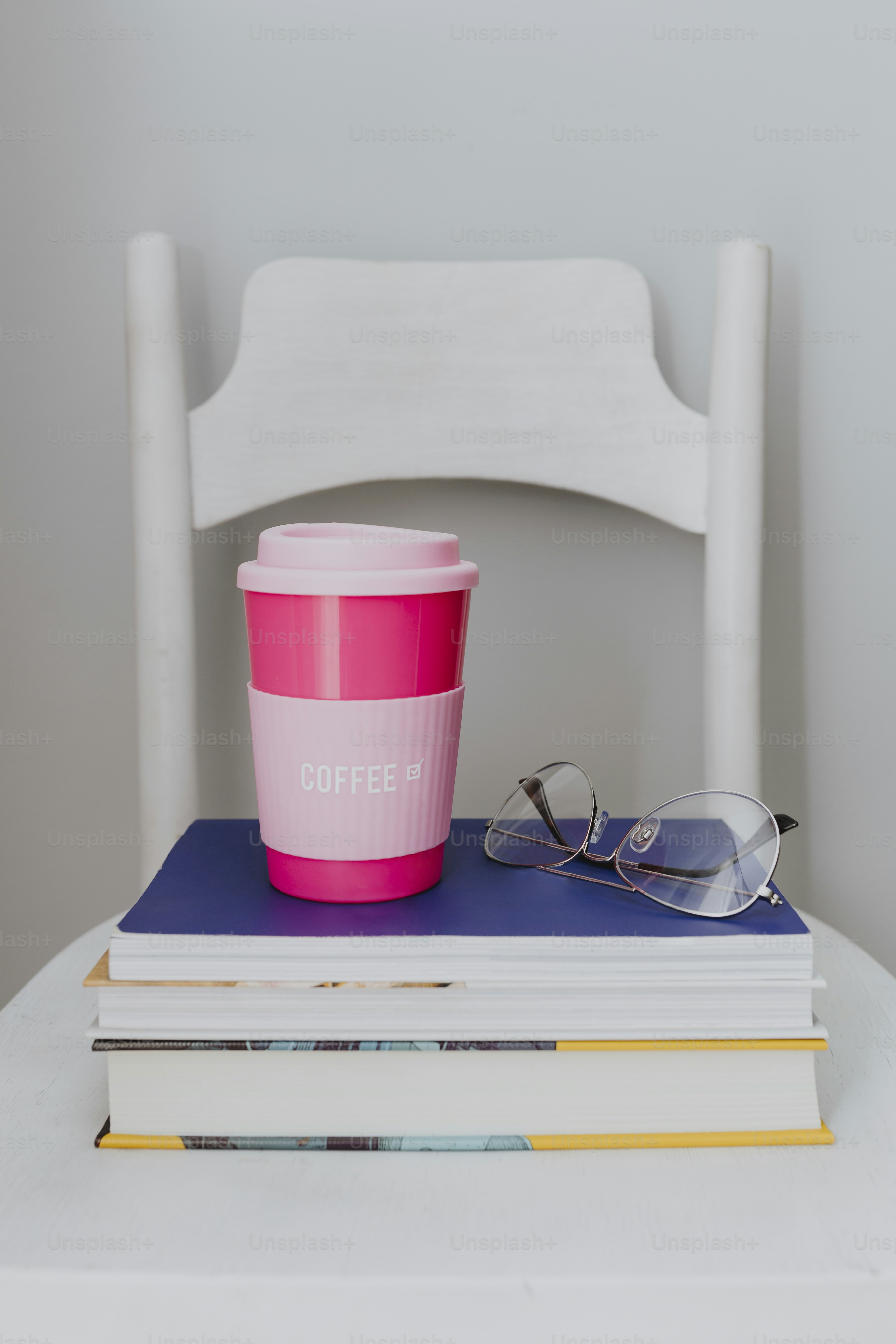 Pink travel mug on a stack of textbooks photo – Book Image on Unsplash