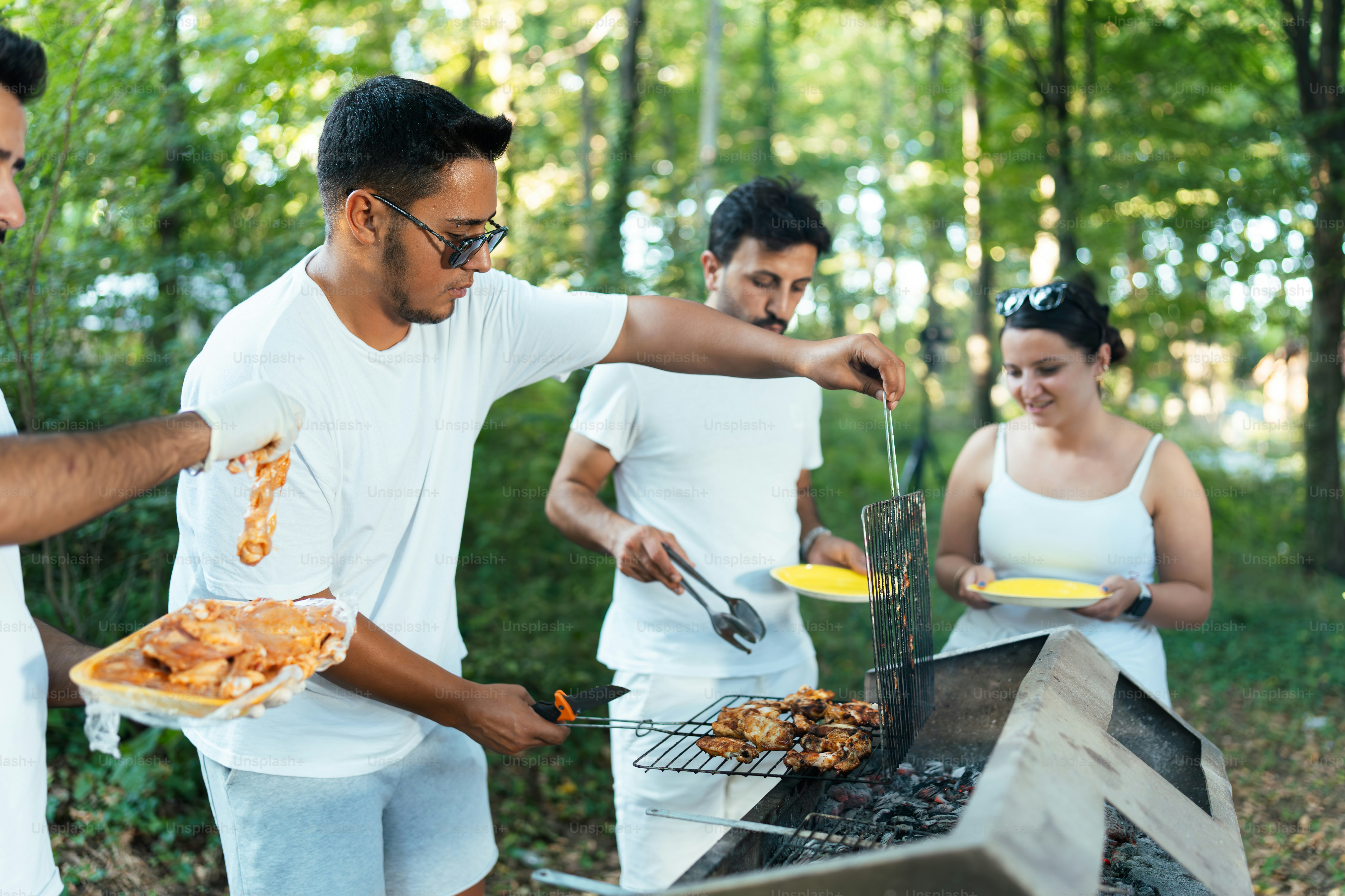 A group of people standing around a bbq grill photo – Barbecue Image on ...