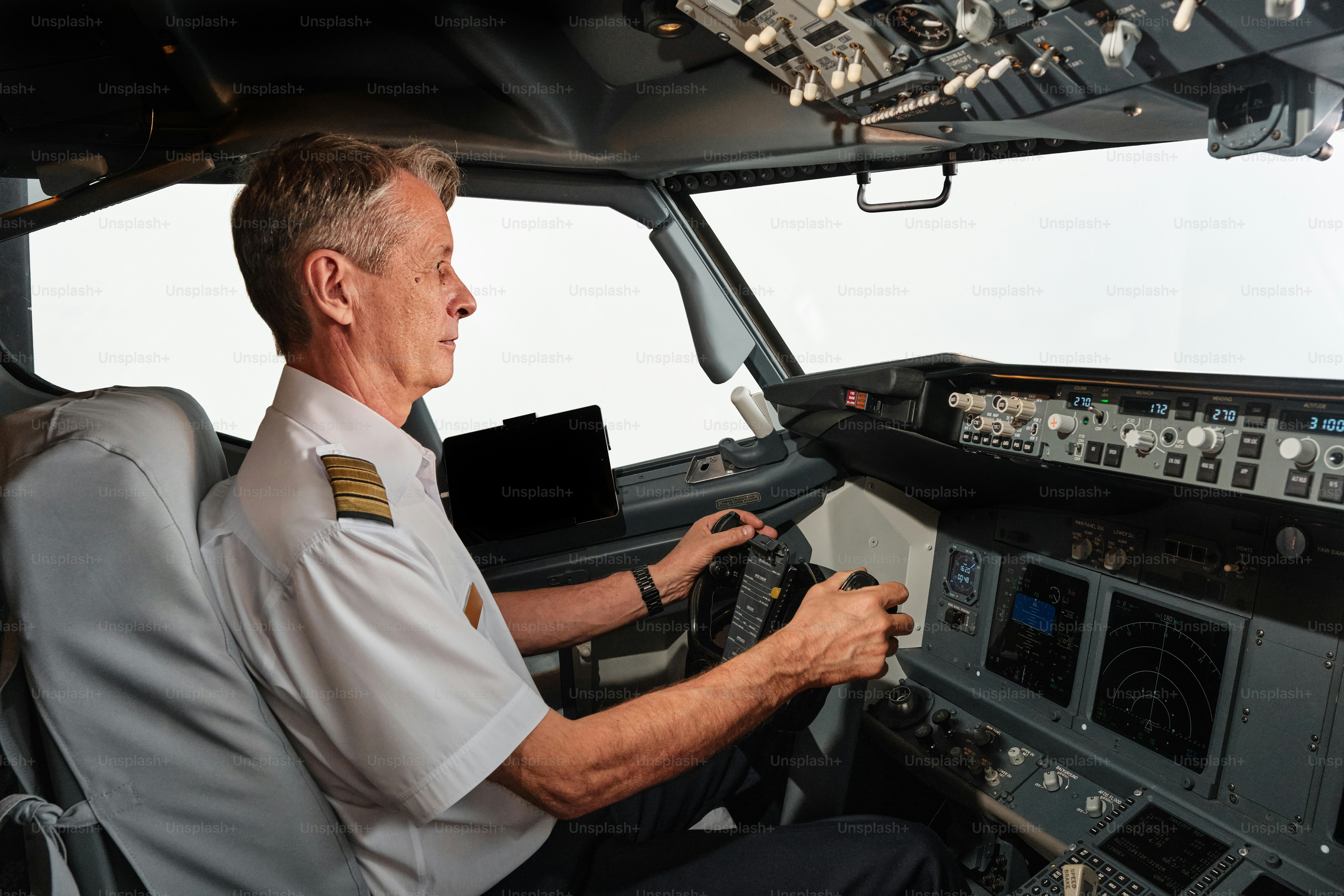 A couple of men sitting in the cockpit of a plane photo – Travel Image ...
