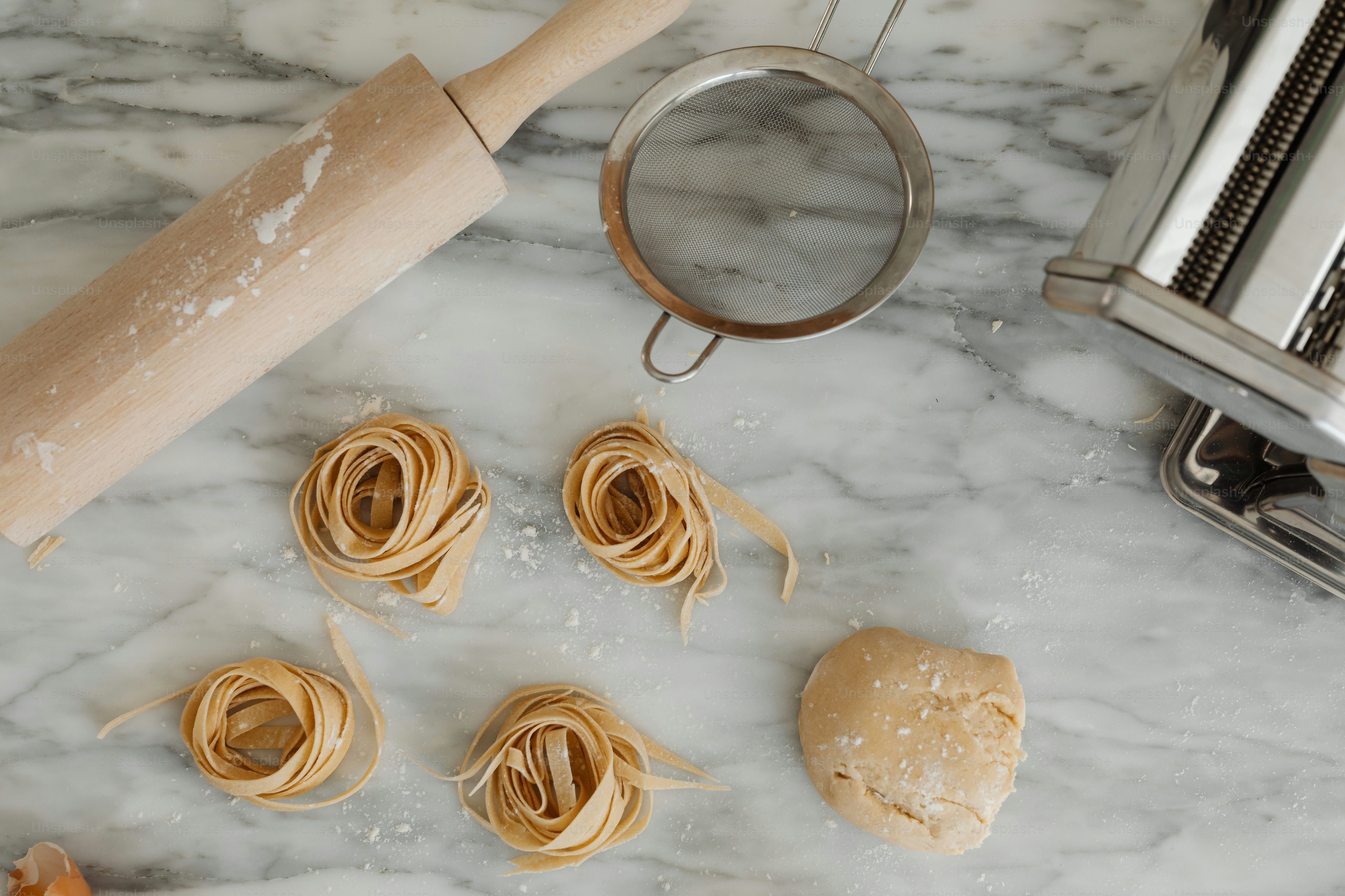 A marble counter topped with pasta and a rolling pin photo – Pasta ...