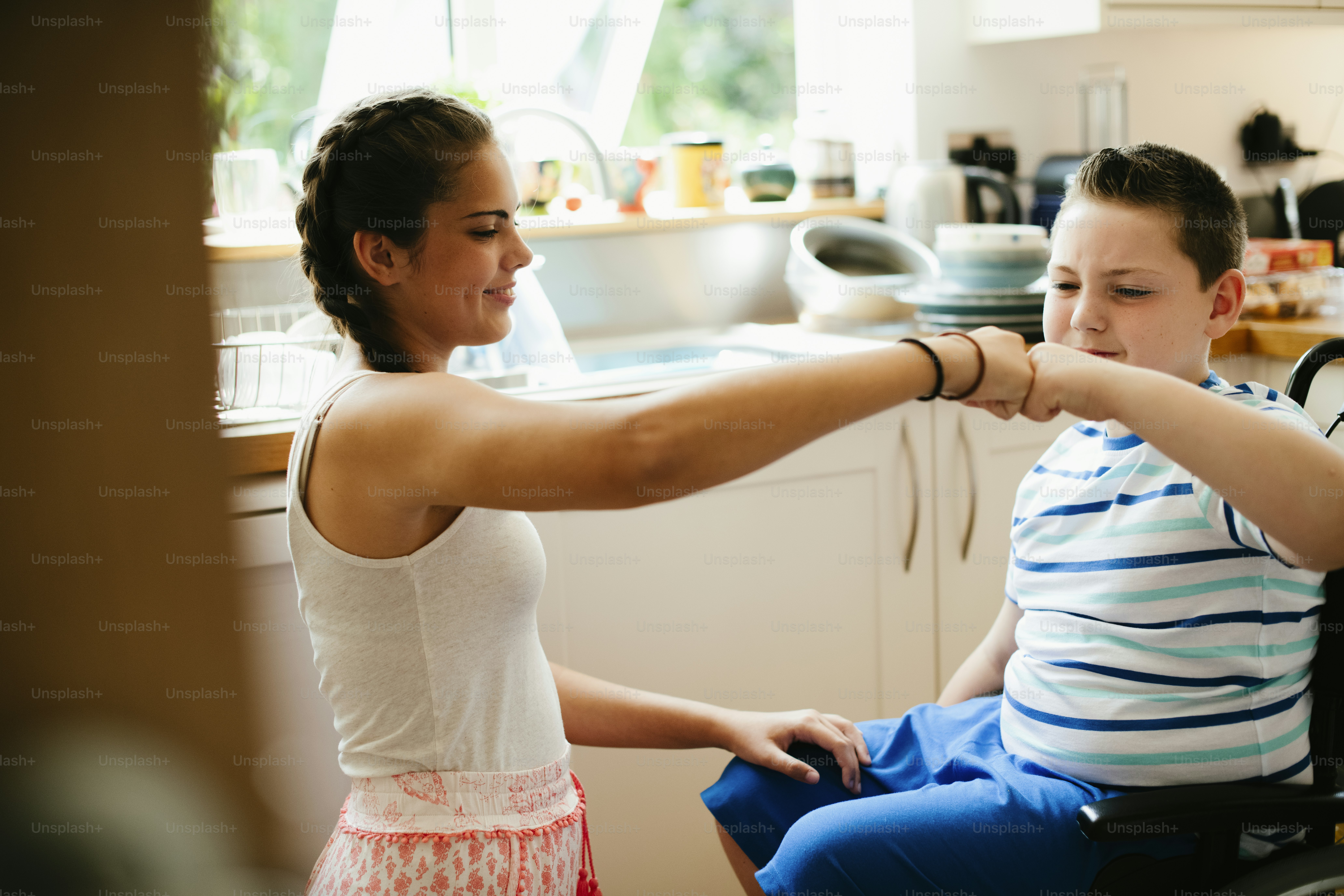 Sister helping her disabled brother in the kitchen photo – Photography ...
