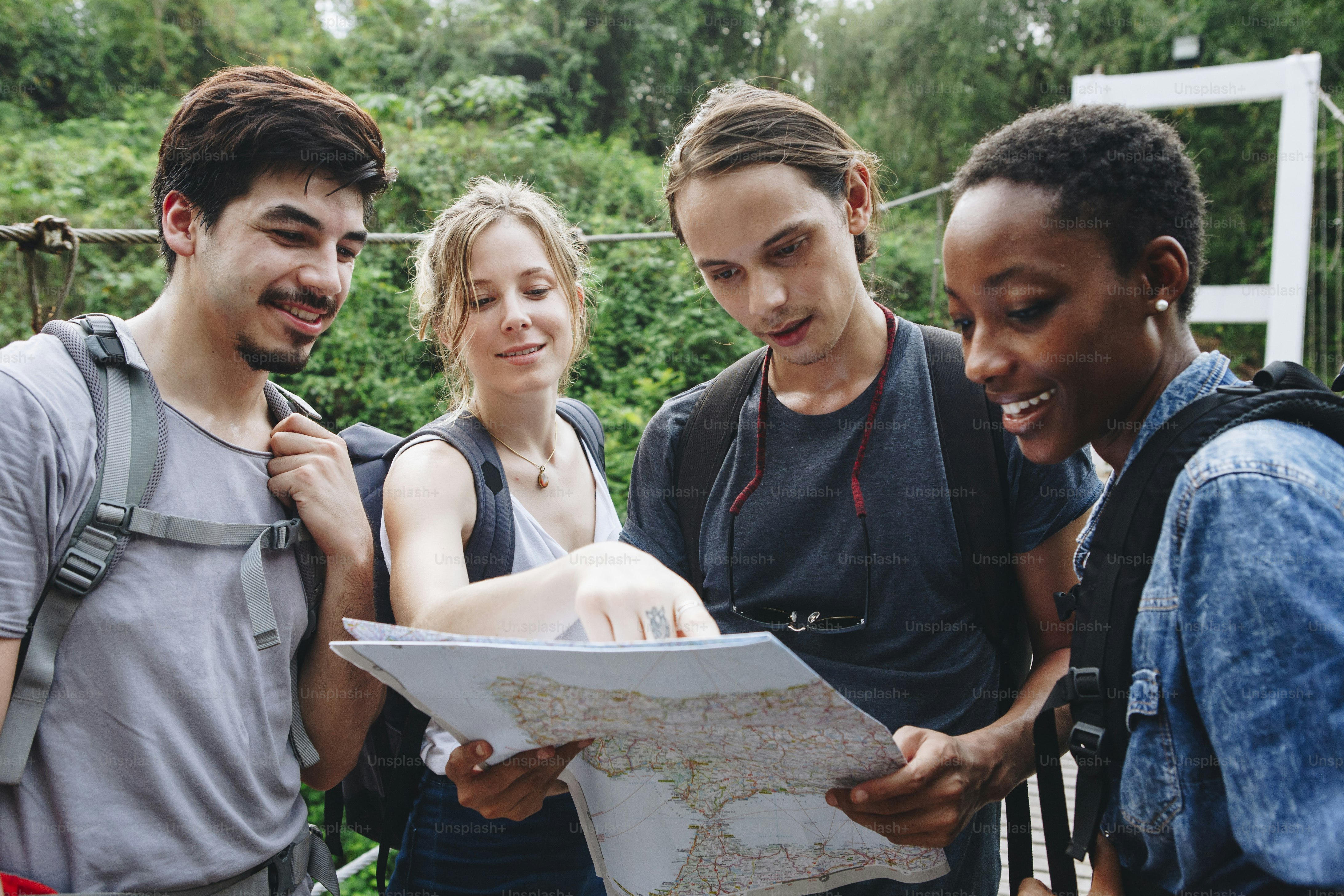 Group of friends looking at a map together travel and teamwork concept ...
