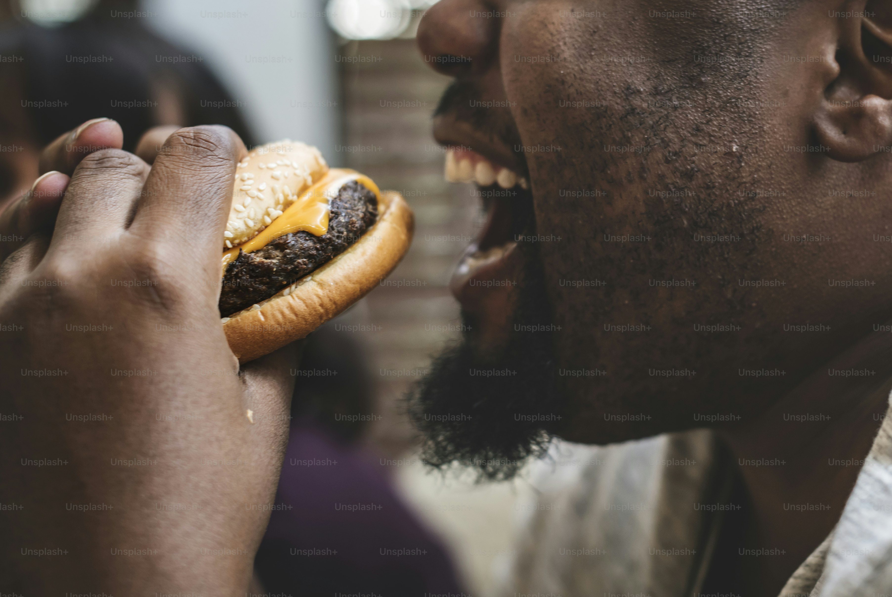 Man eating a big hamburger photo – Black people Image on Unsplash