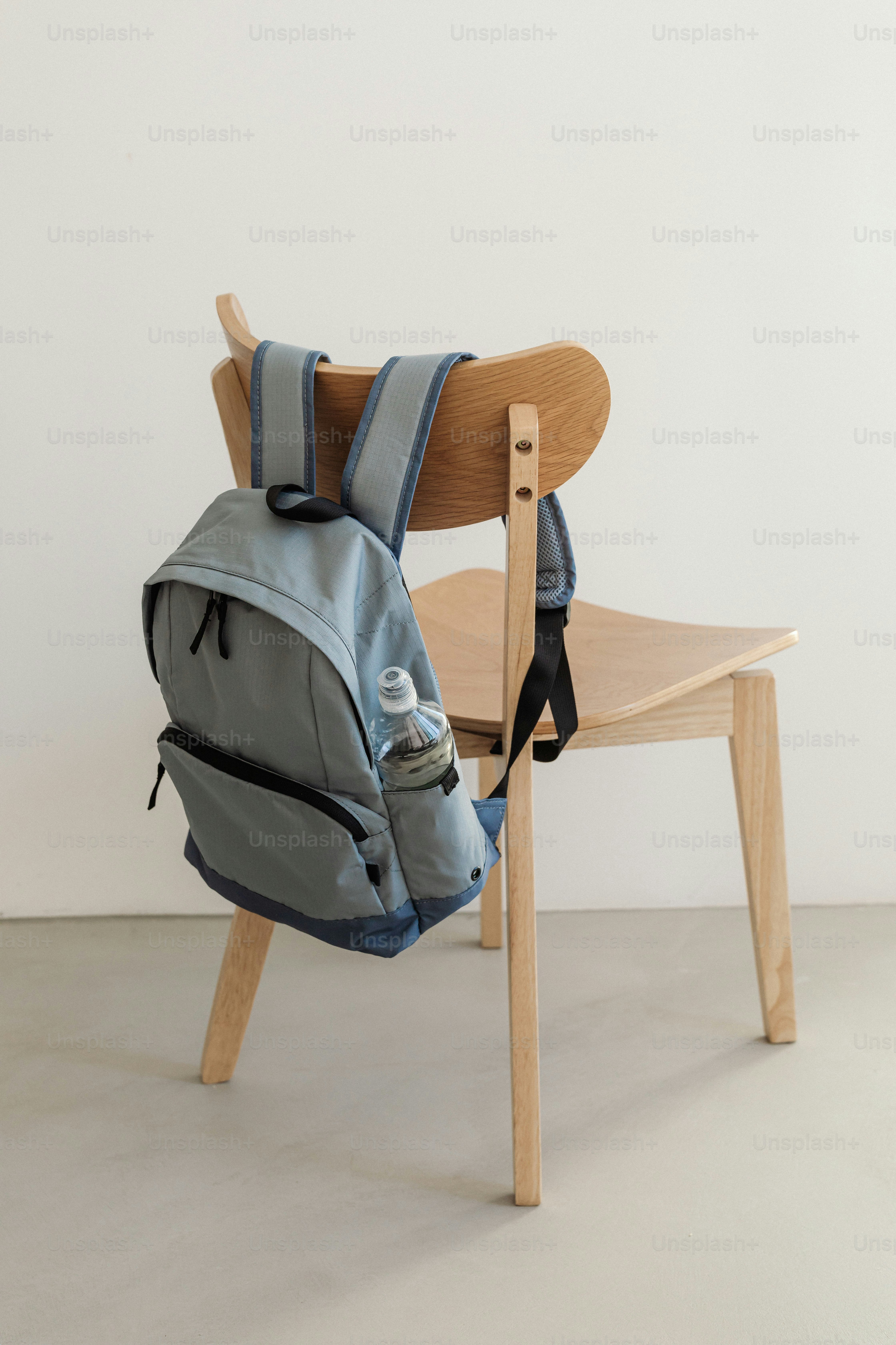 A backpack sitting on a chair in a room photo – Back to school Image on ...