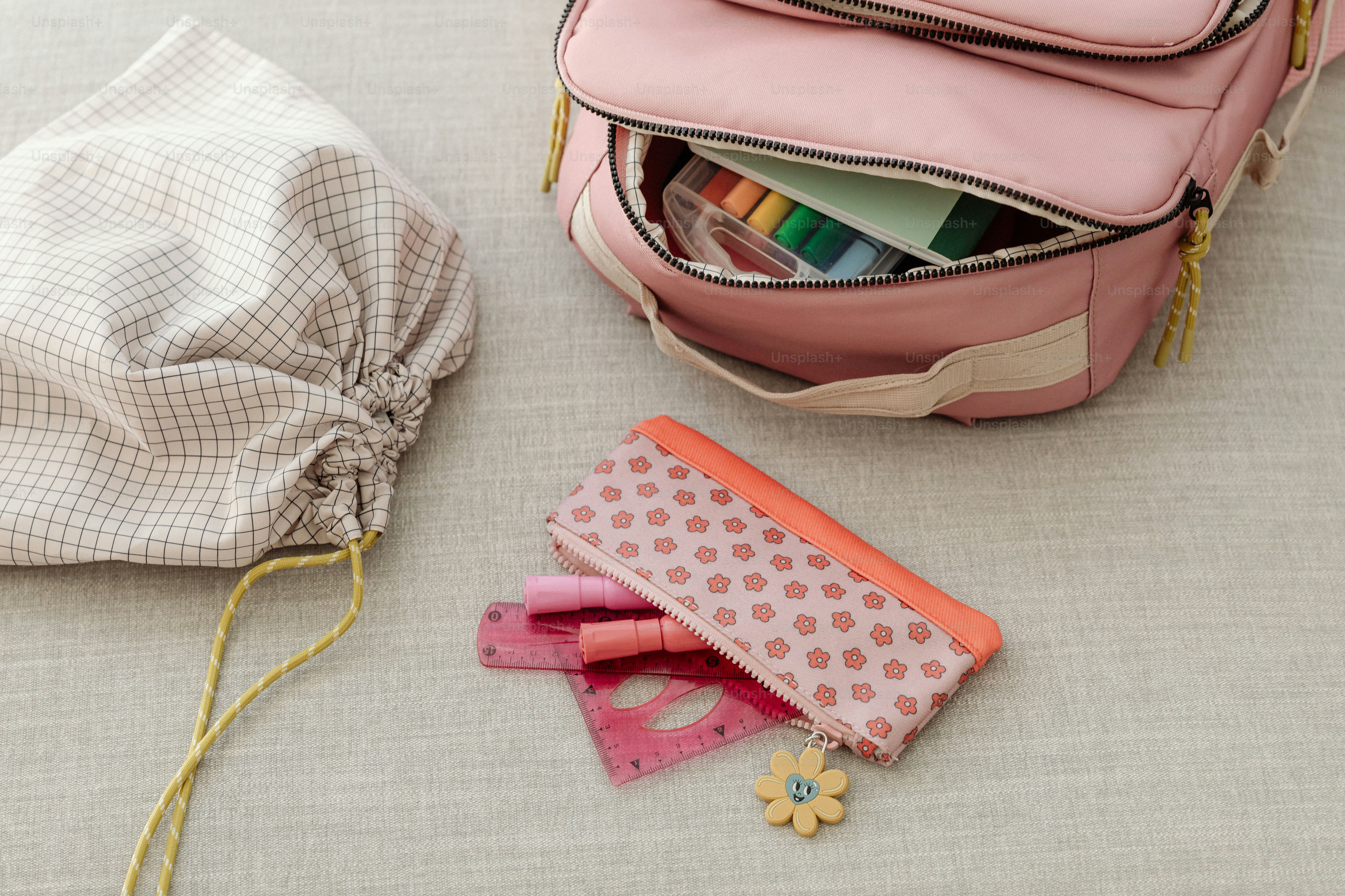 A pink backpack filled with markers, pencils, and markers photo ...
