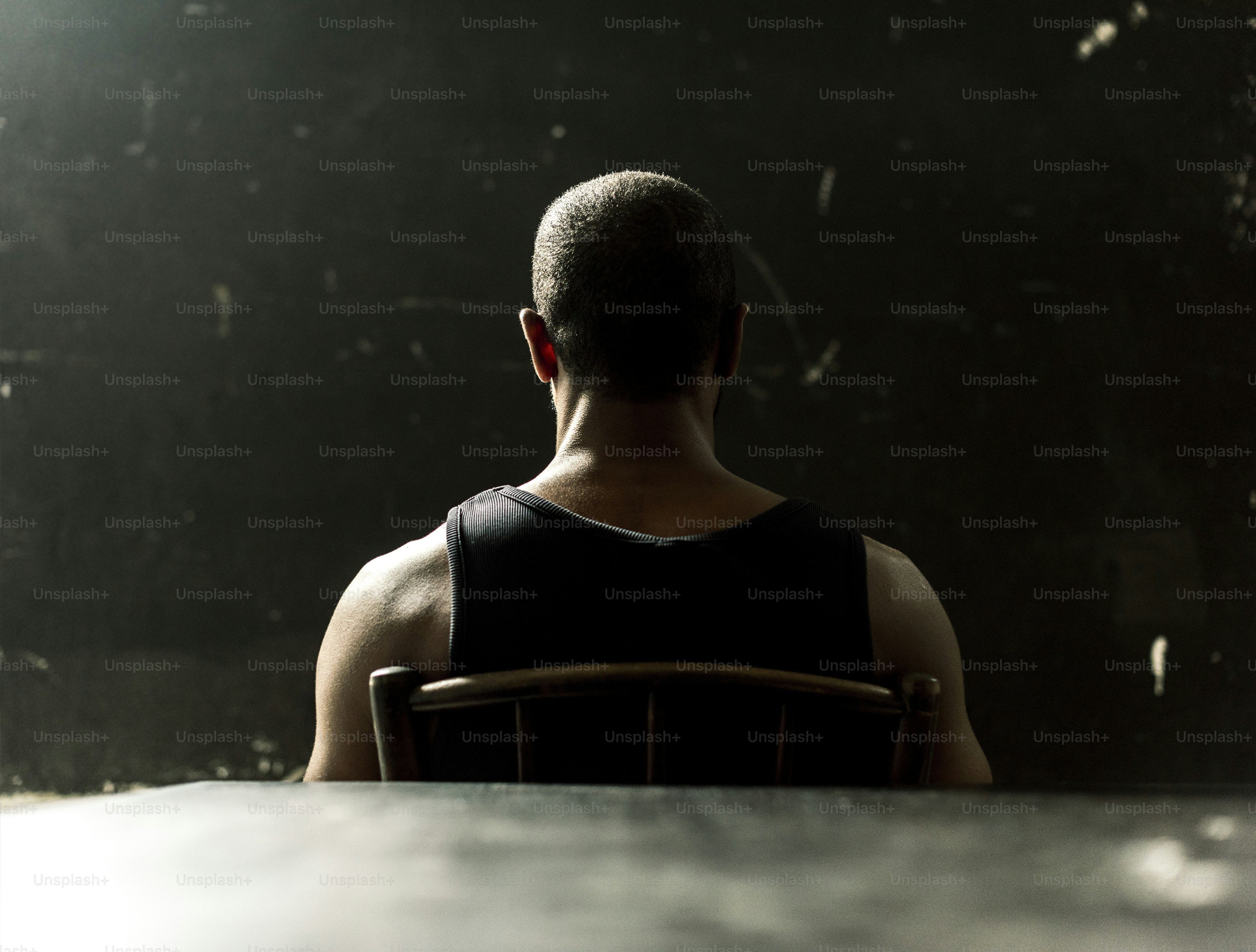 African man rear view sitting on the chair photo – Skinhead Image on ...