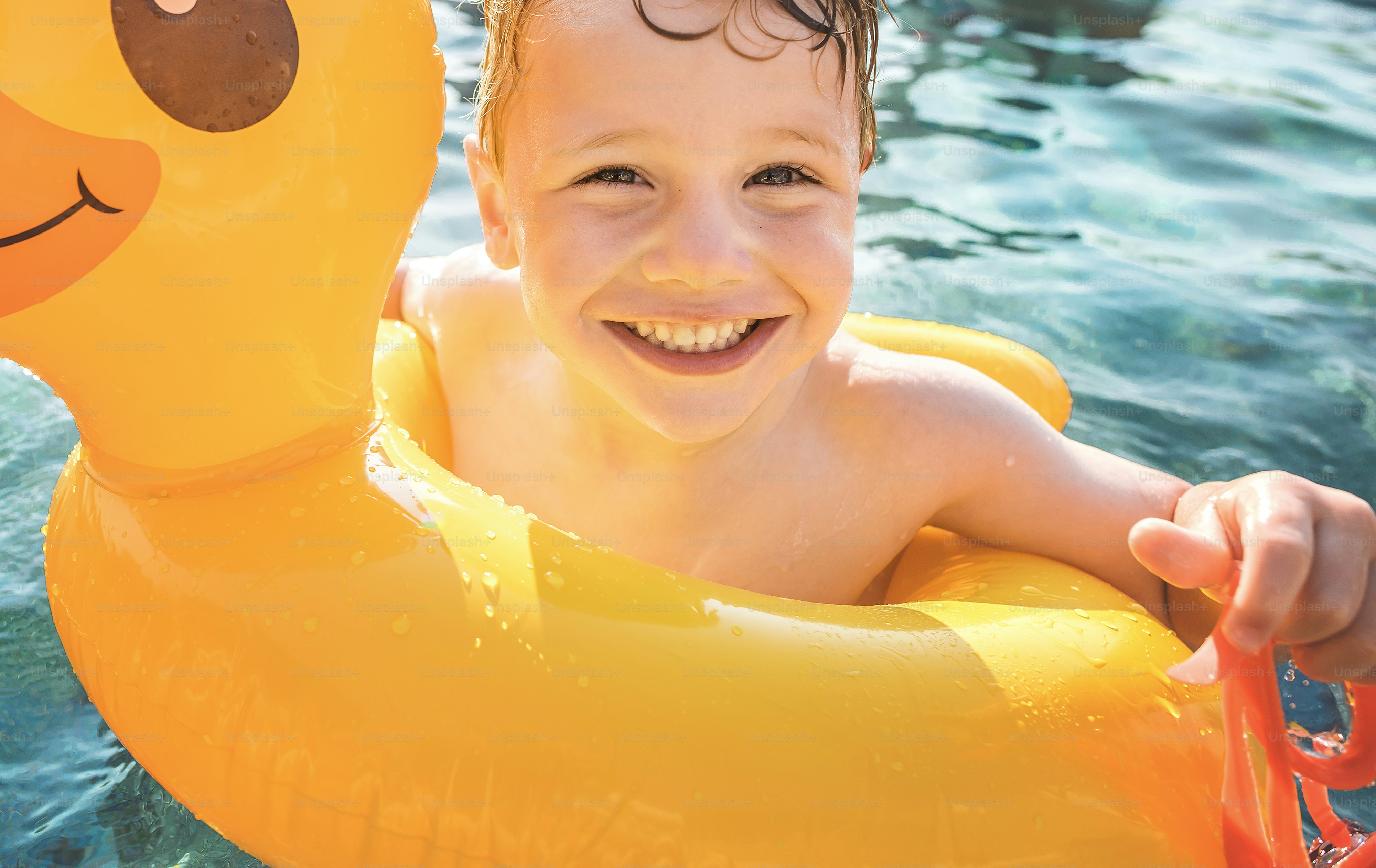 Happy boy and a yellow duck tube in the pool photo – Summer Image on ...