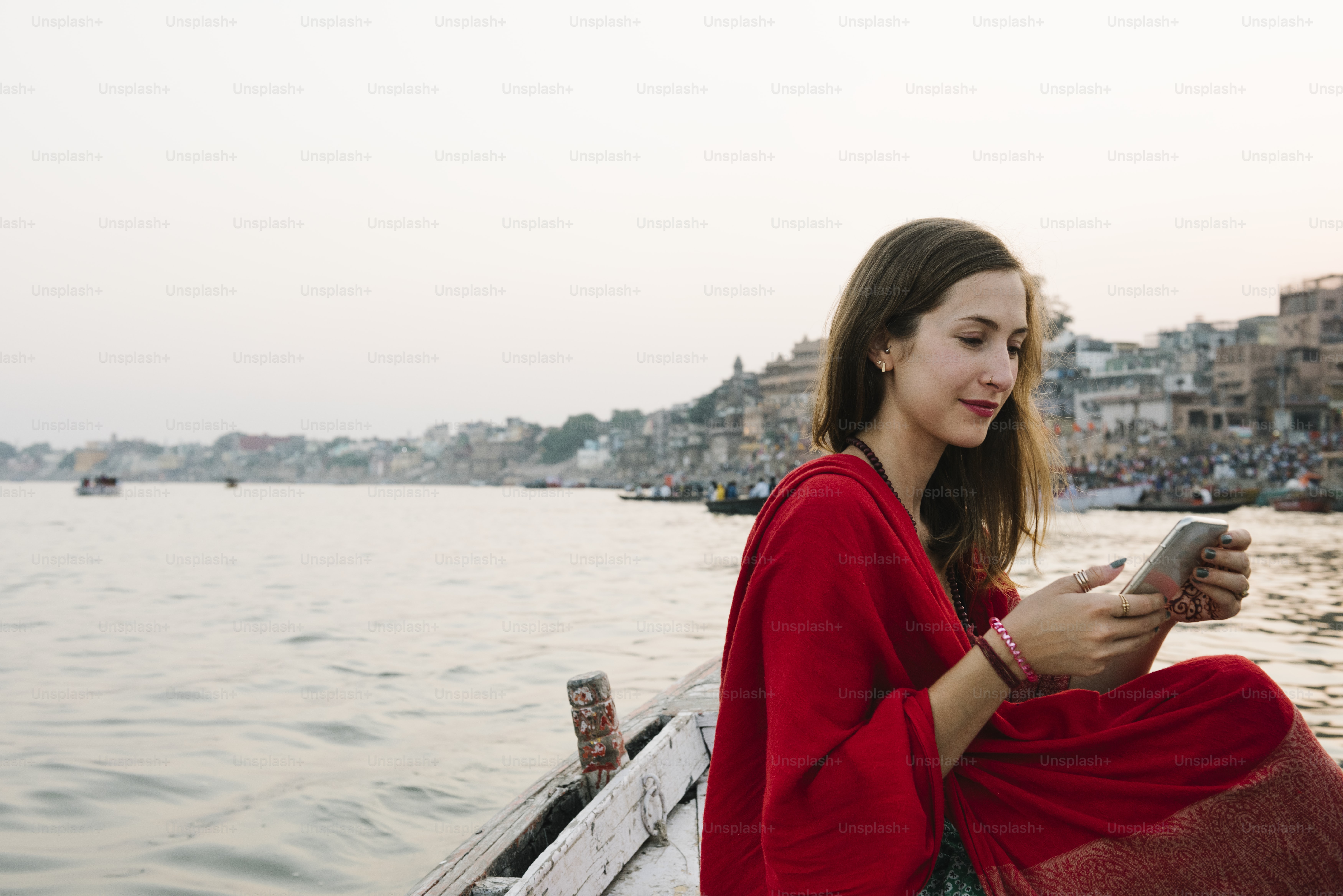 Western woman on a boat texting from the River Ganges photo – One ...