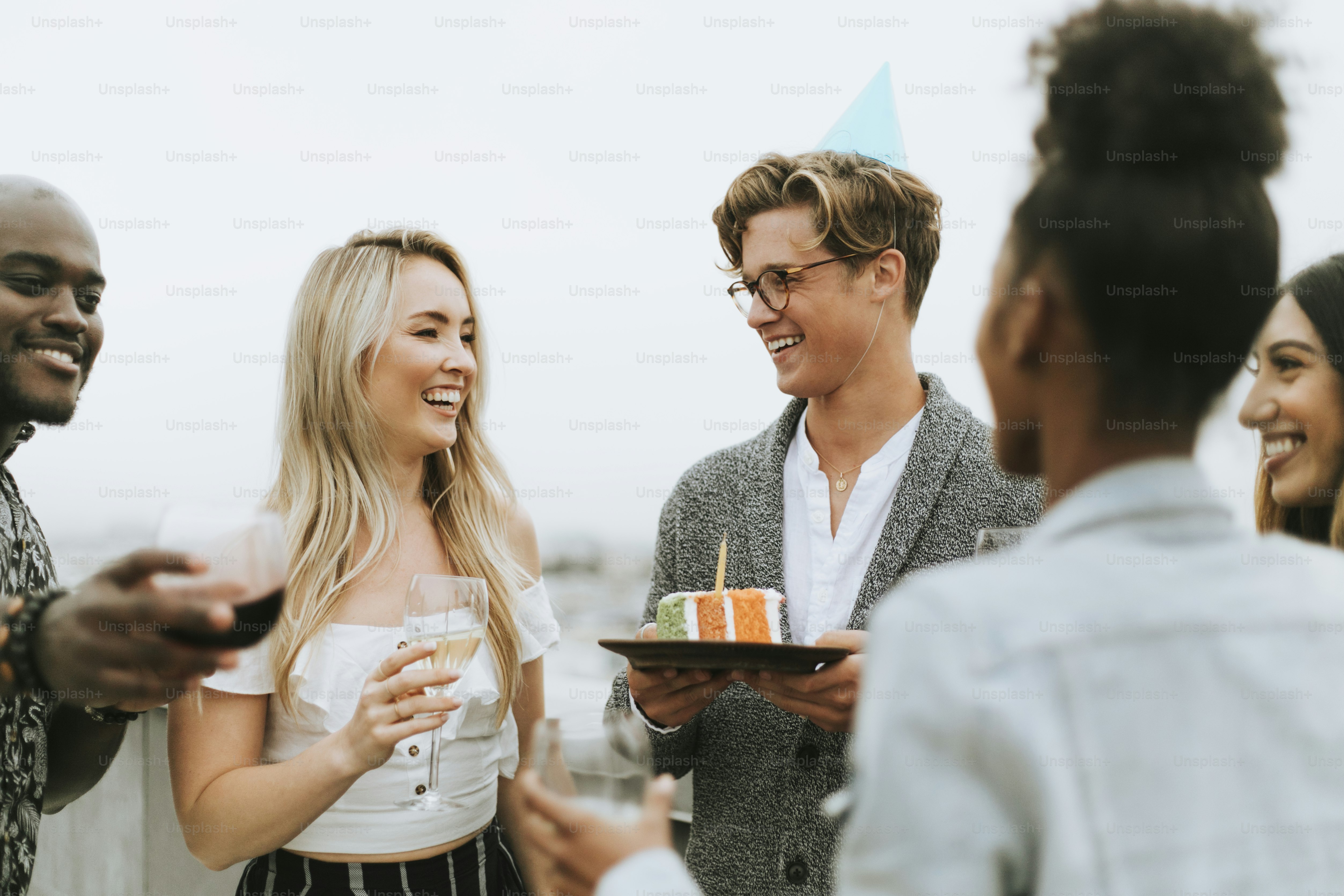 Cheerful friends celebrating at a rooftop birthday party photo ...