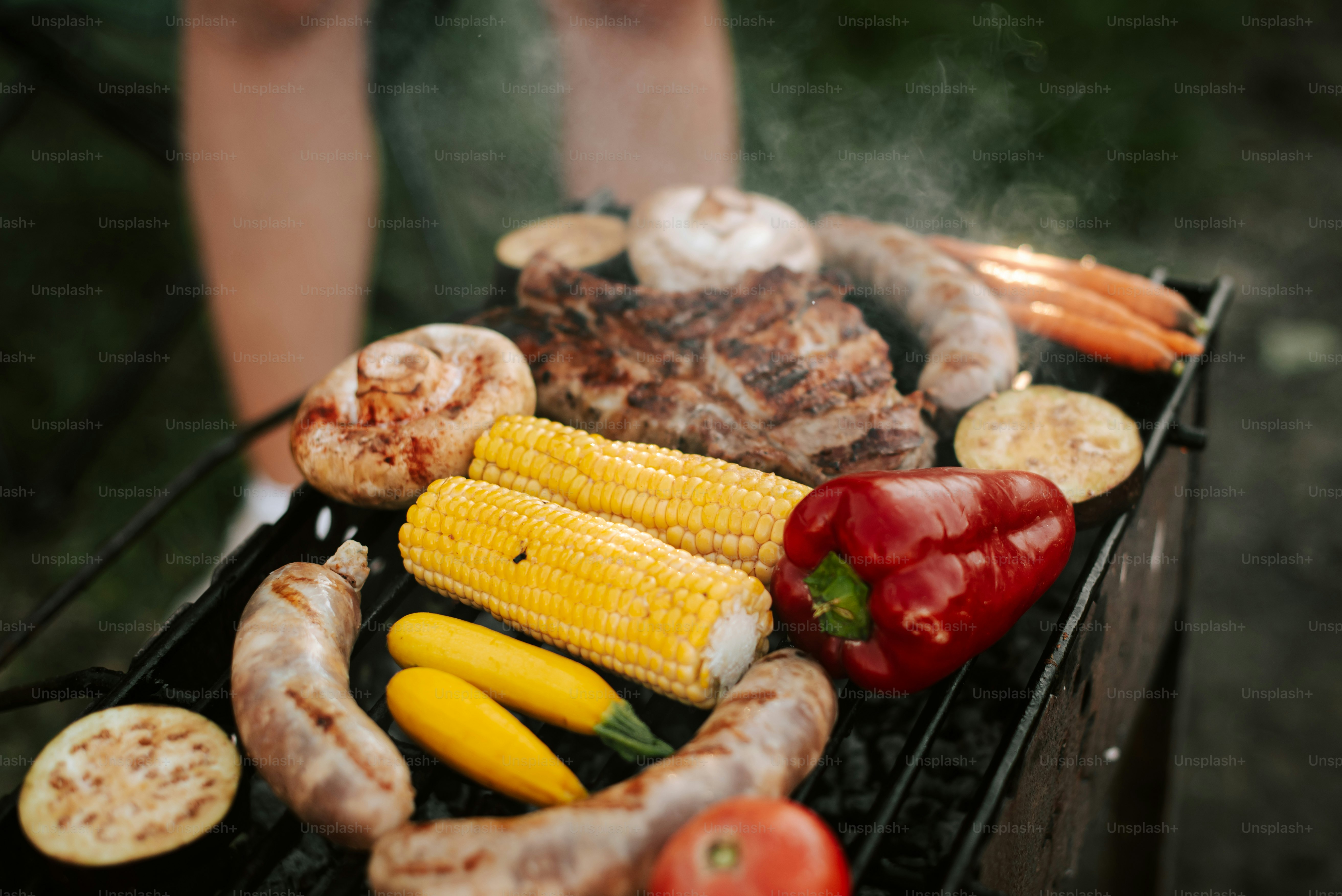 Ein Grill mit einem Haufen Speisen, die darauf kochen Foto – Bild zum ...