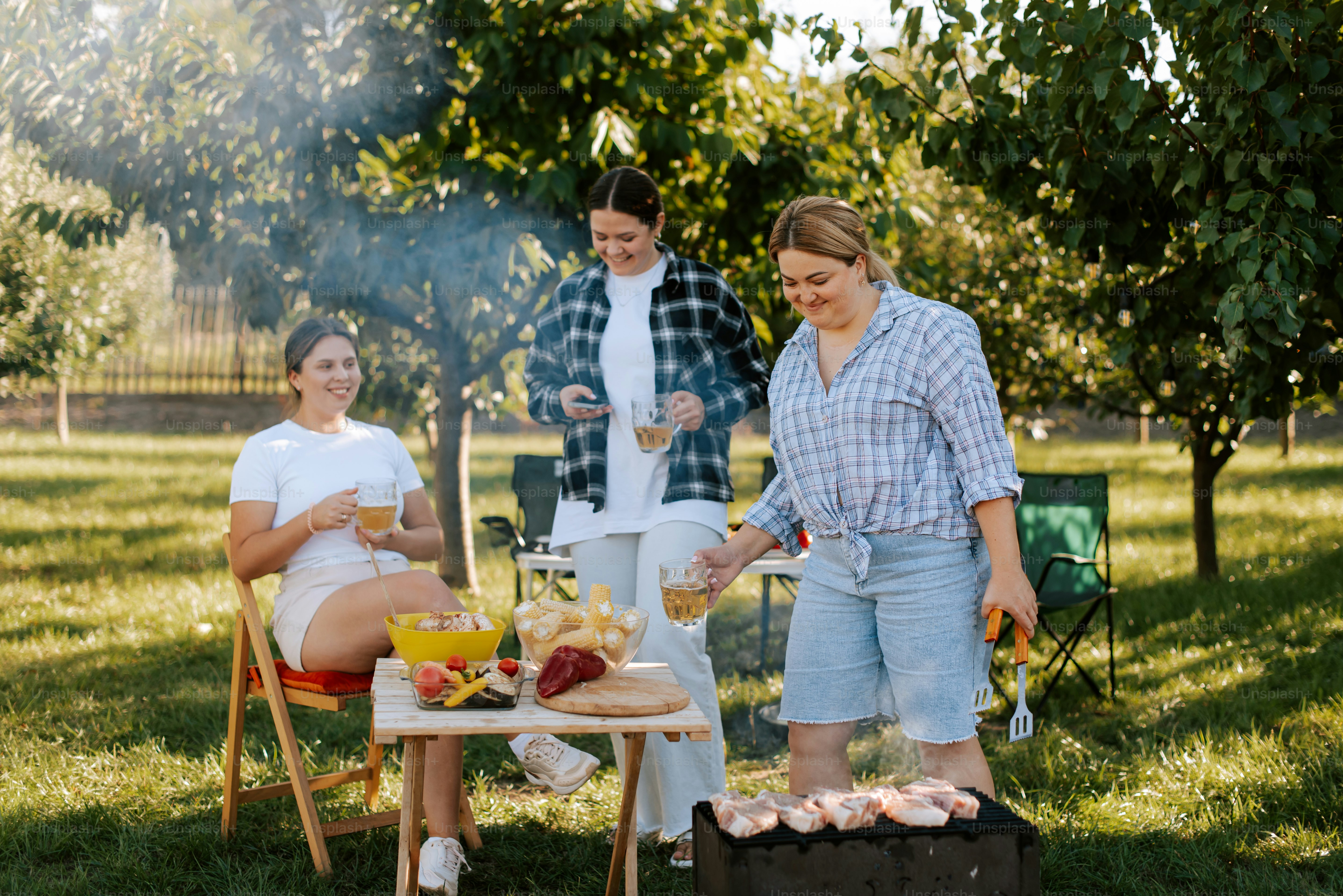 A group of people standing around a bbq grill photo – Family Image on ...