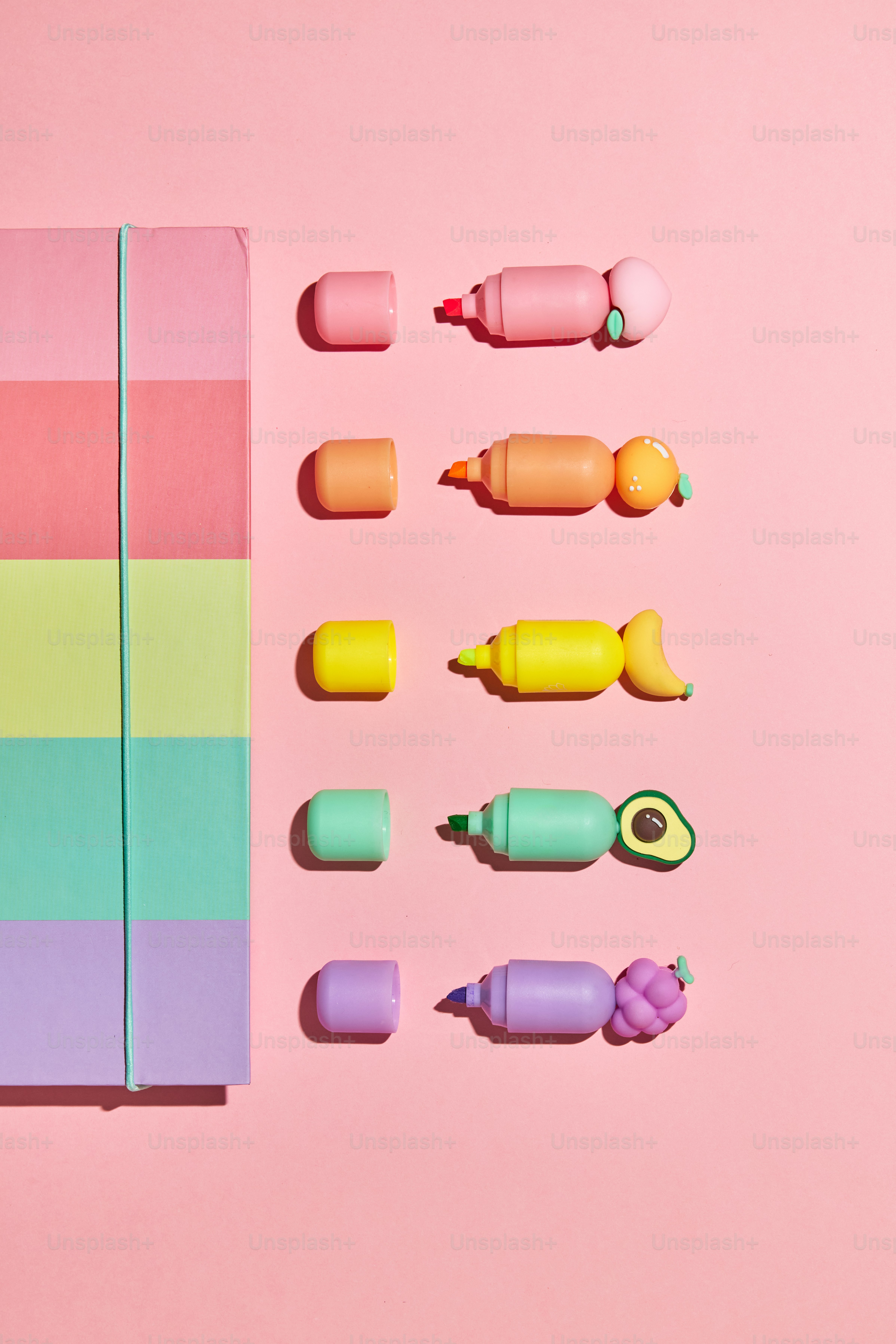 A pink notebook with pastel colored candy on top of it photo – School ...