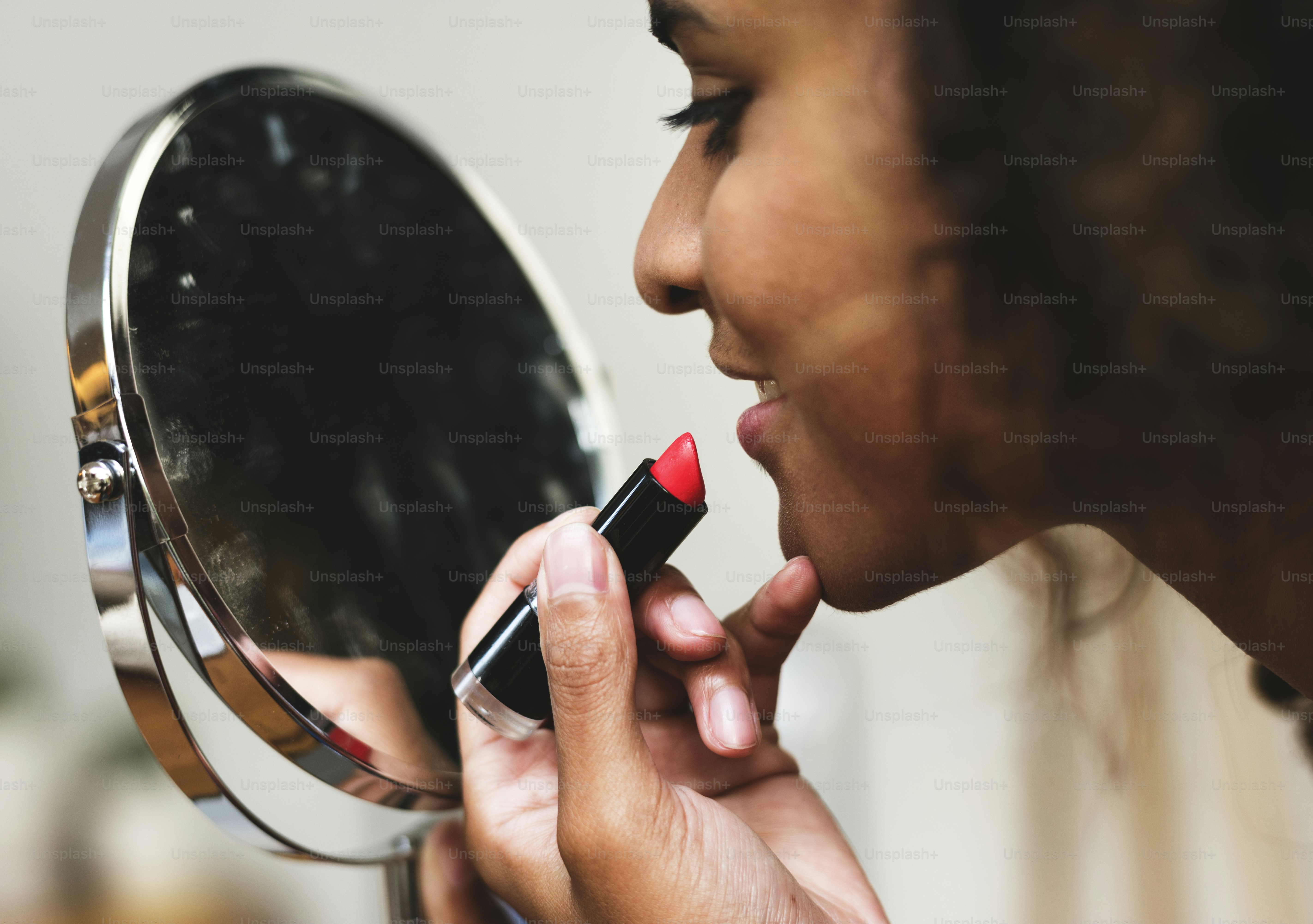 Mujer poniéndose lápiz labial en el espejo foto – Imagen de Persona de ...