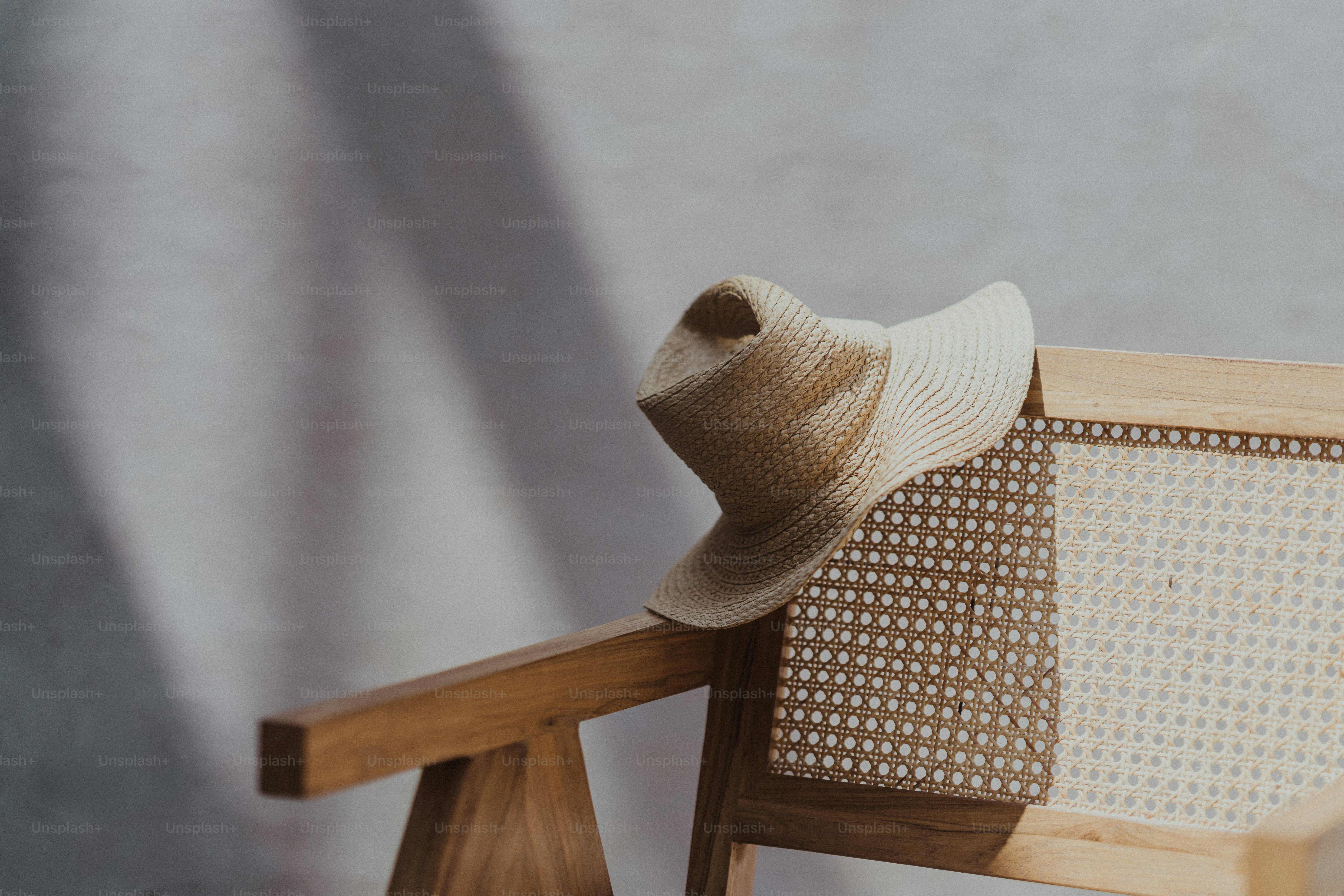A wooden chair with a hat on top of it photo – Hat Image on Unsplash