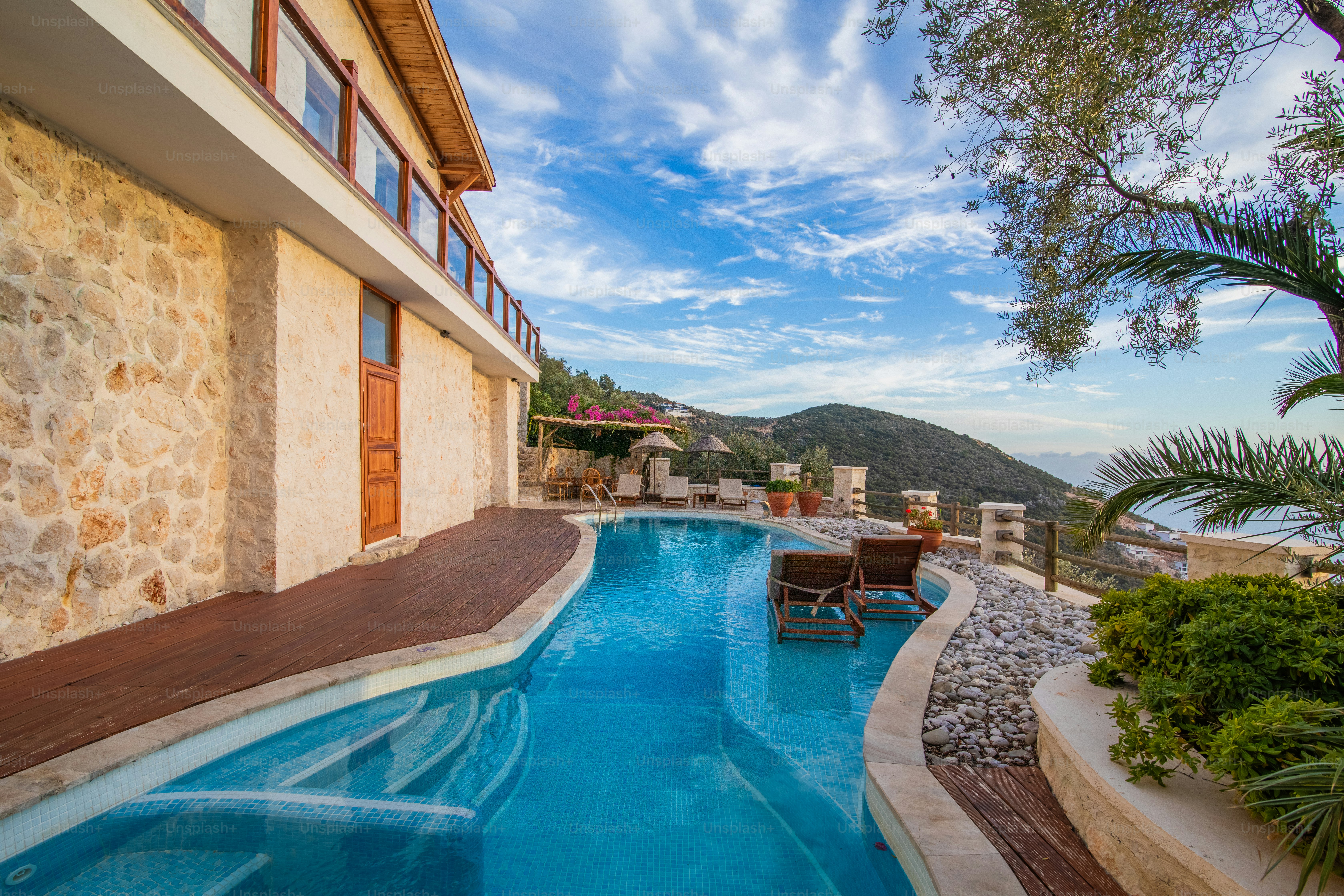 A large swimming pool next to a wooden deck photo – Swimming pool Image ...