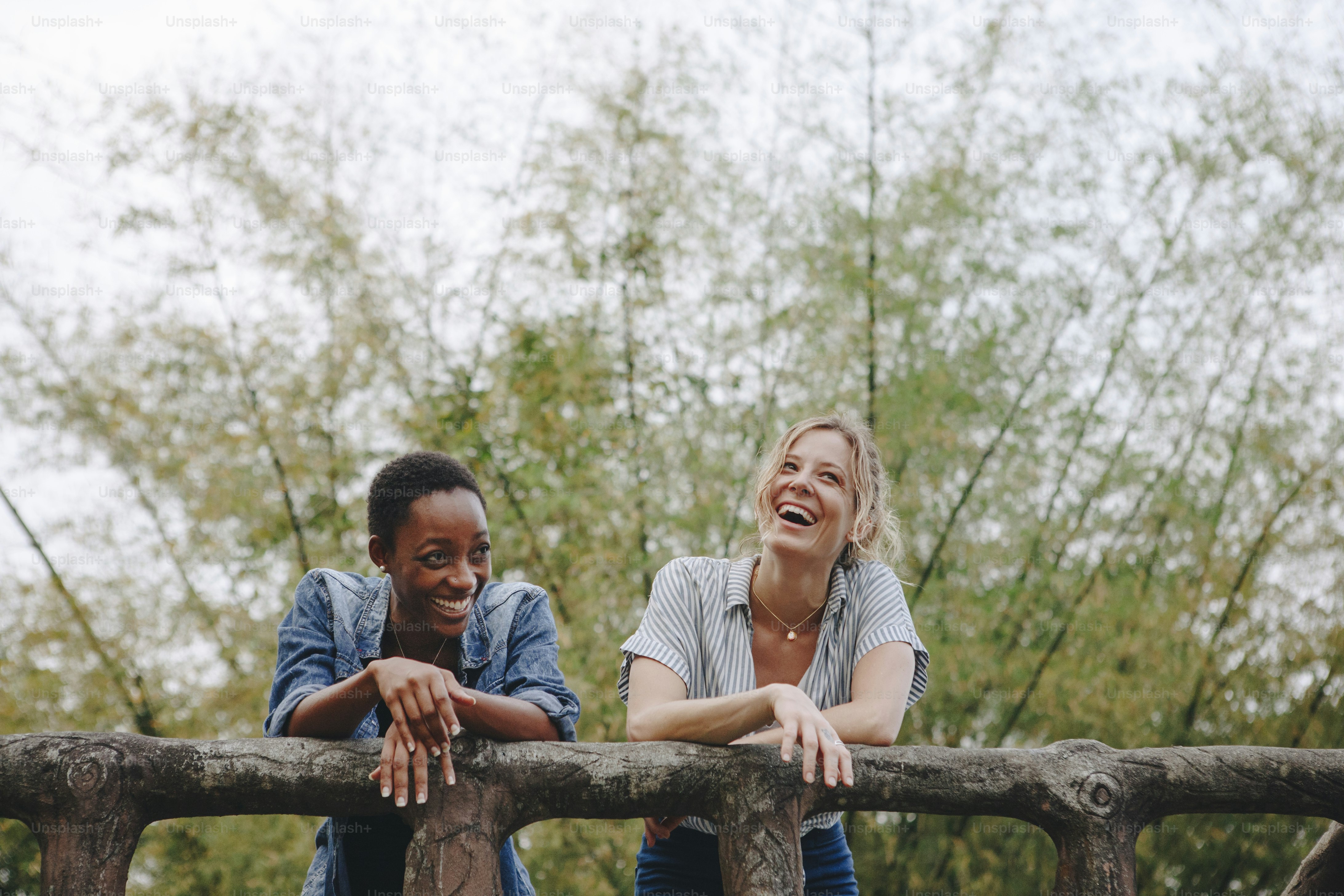 Two young female adult friends outdoors friendship bonding, freedom and ...
