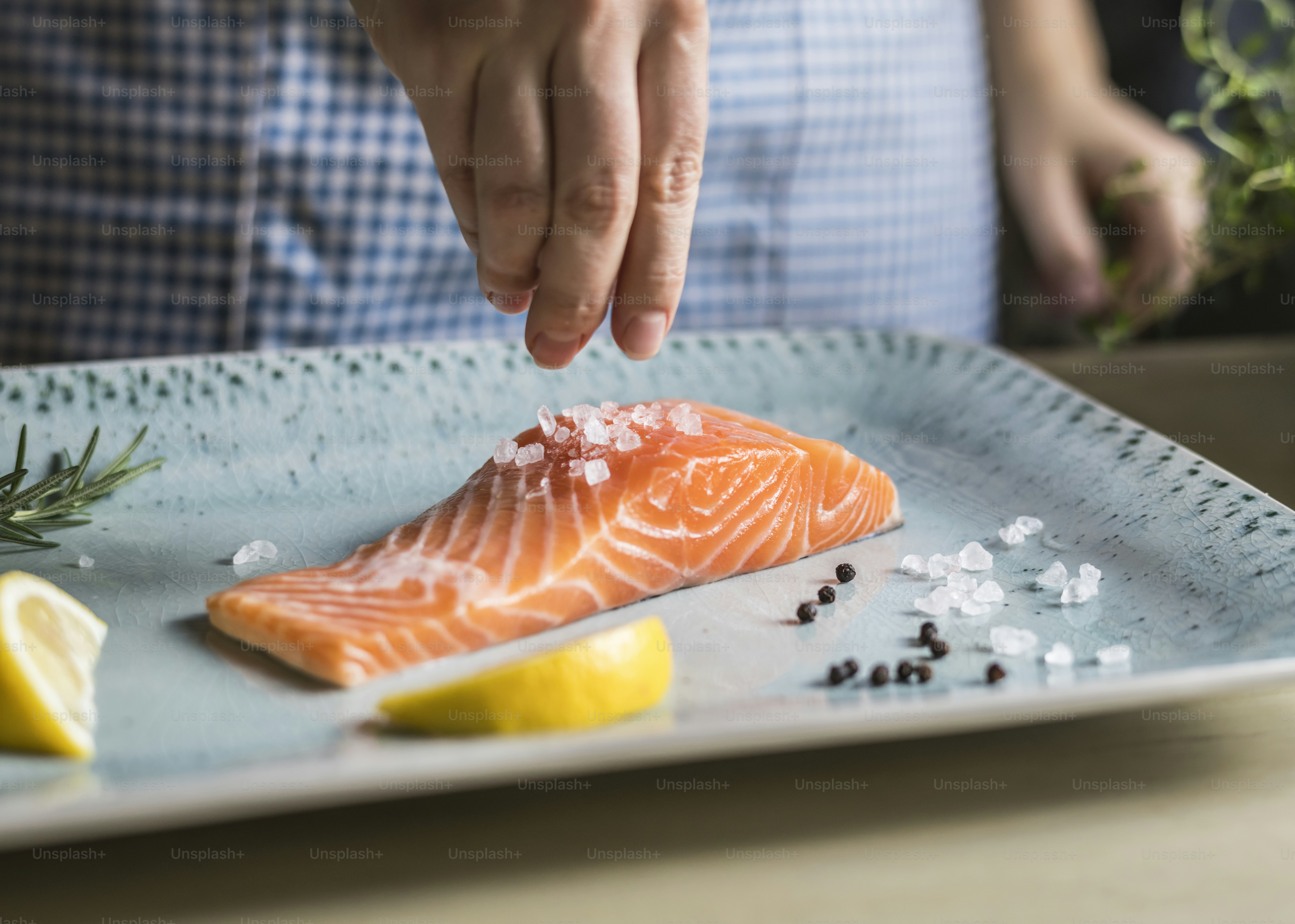 A person seasoning a fillet of salmon food photography recipe idea ...