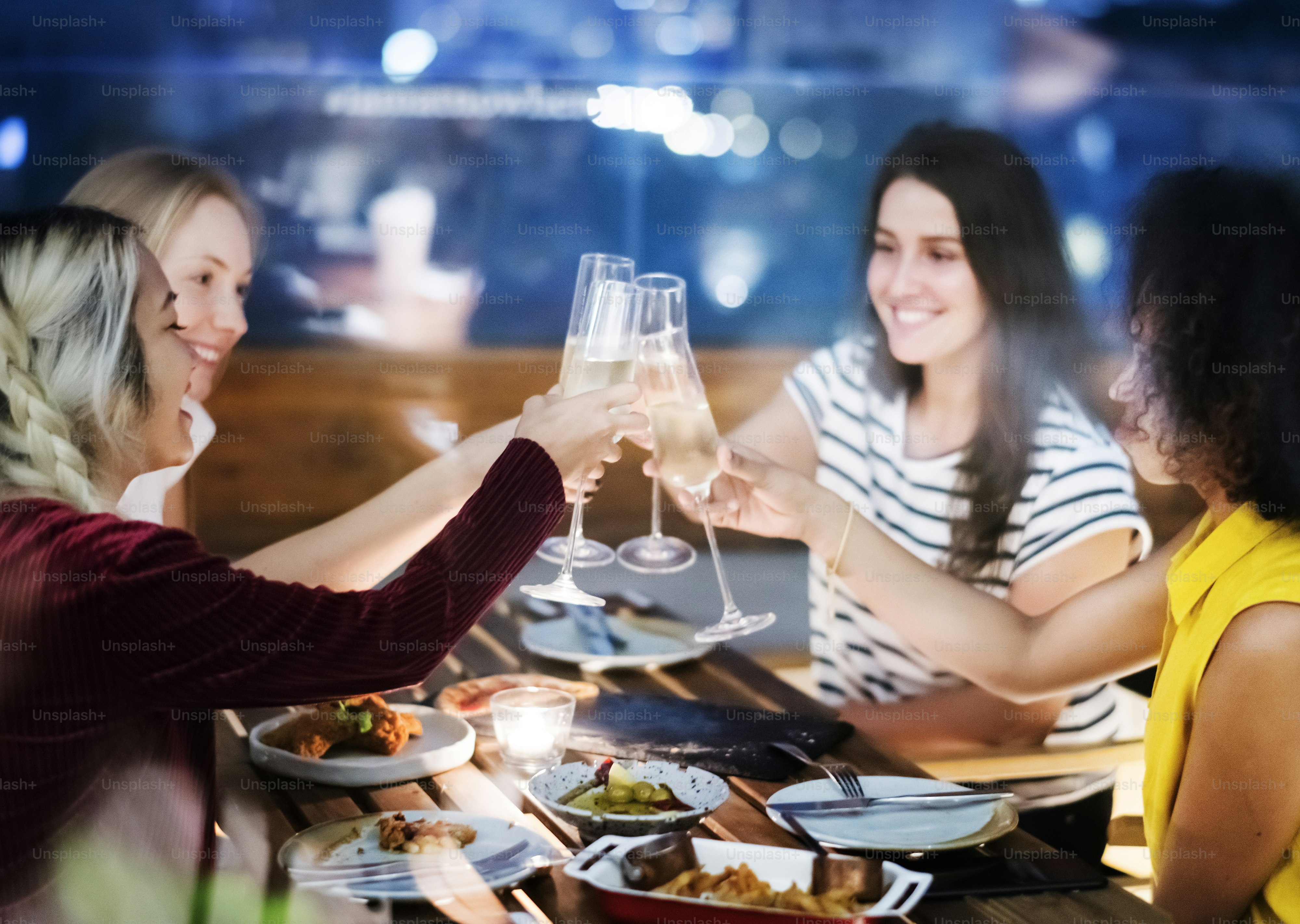 Amigas brindando juntas en la cena en un bar en la azotea foto – Imagen ...