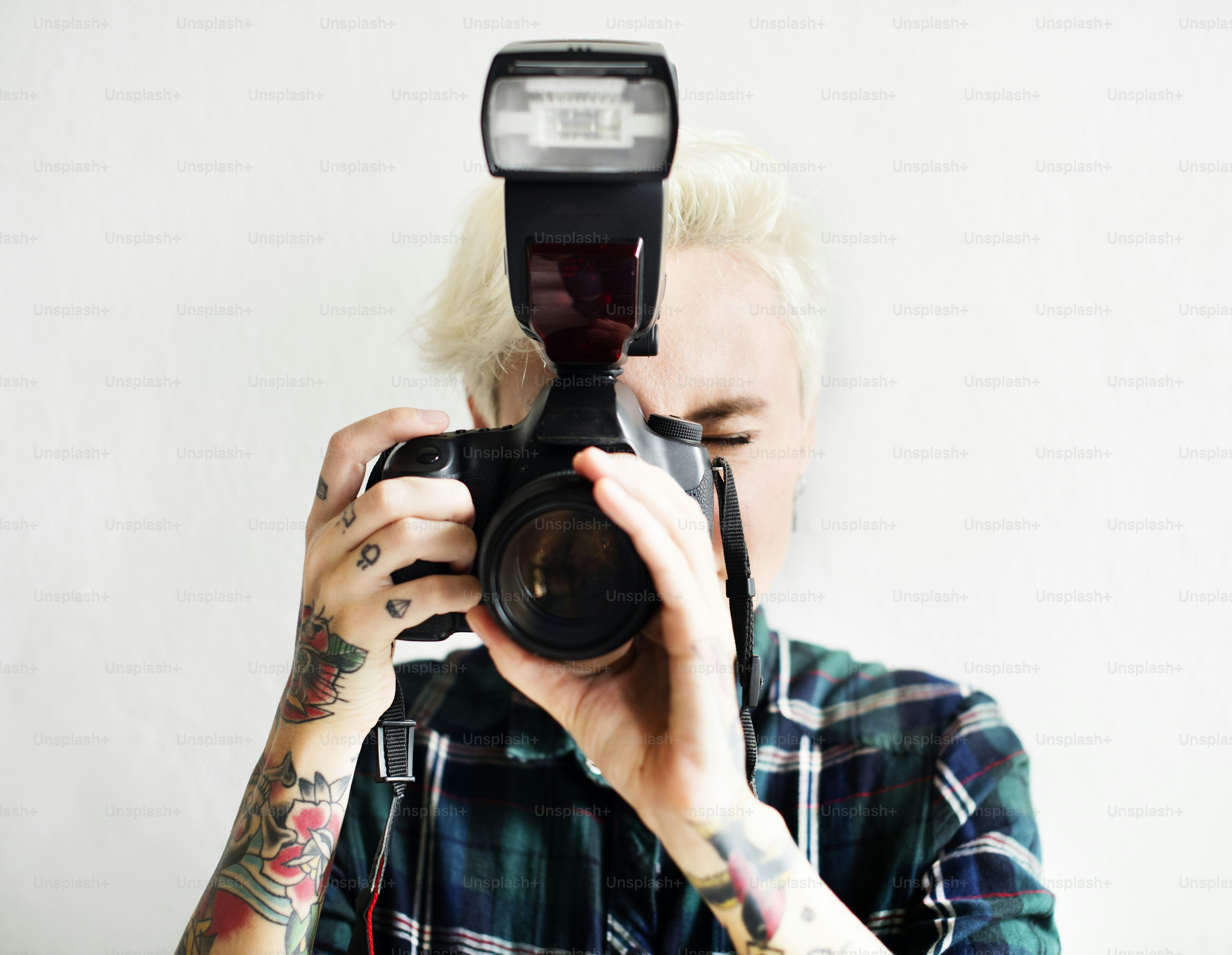 Casual blonde woman with tattoo holding camera taking a snap shot photo ...