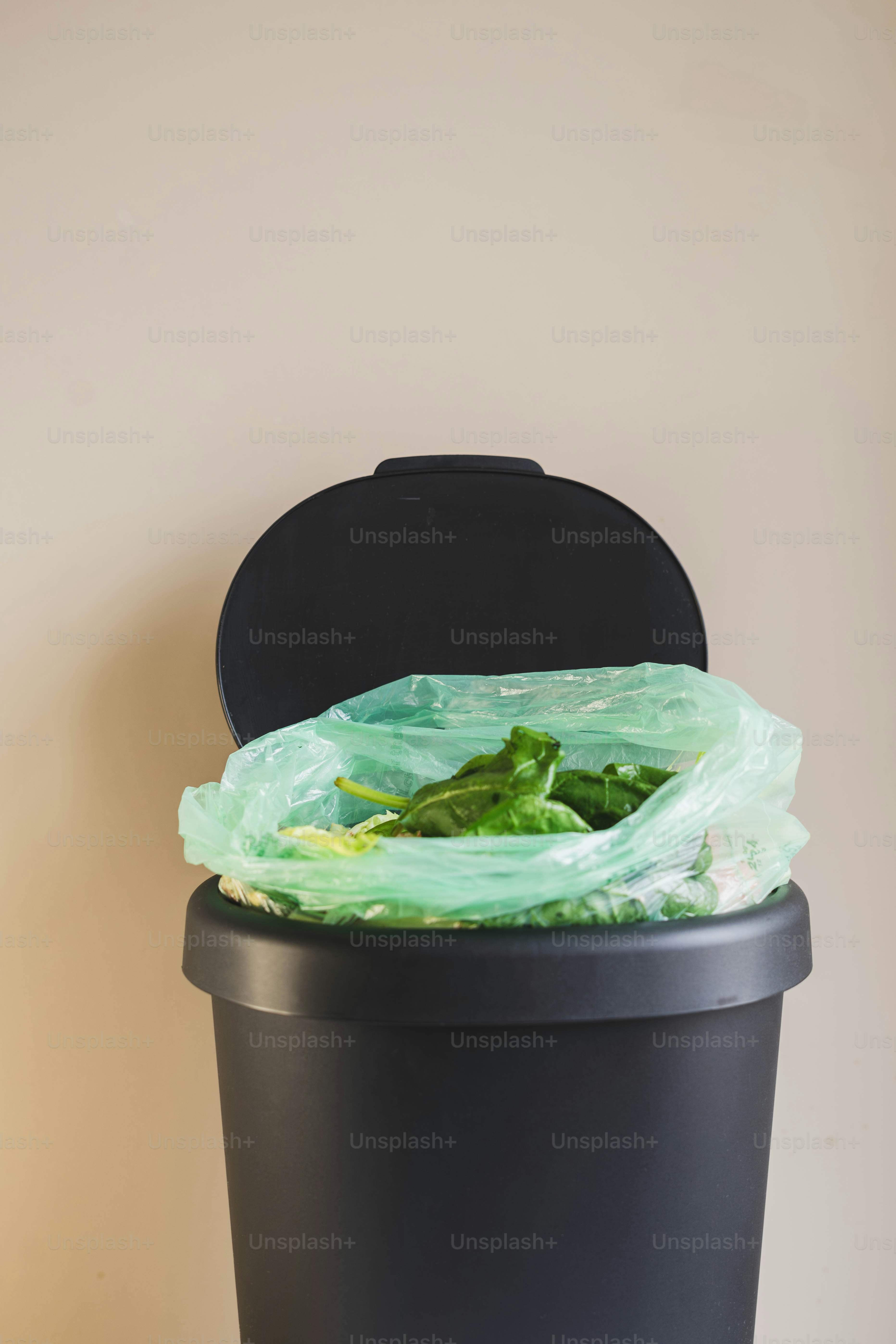 A black trash can with a green cloth in it photo – Waste Image on Unsplash