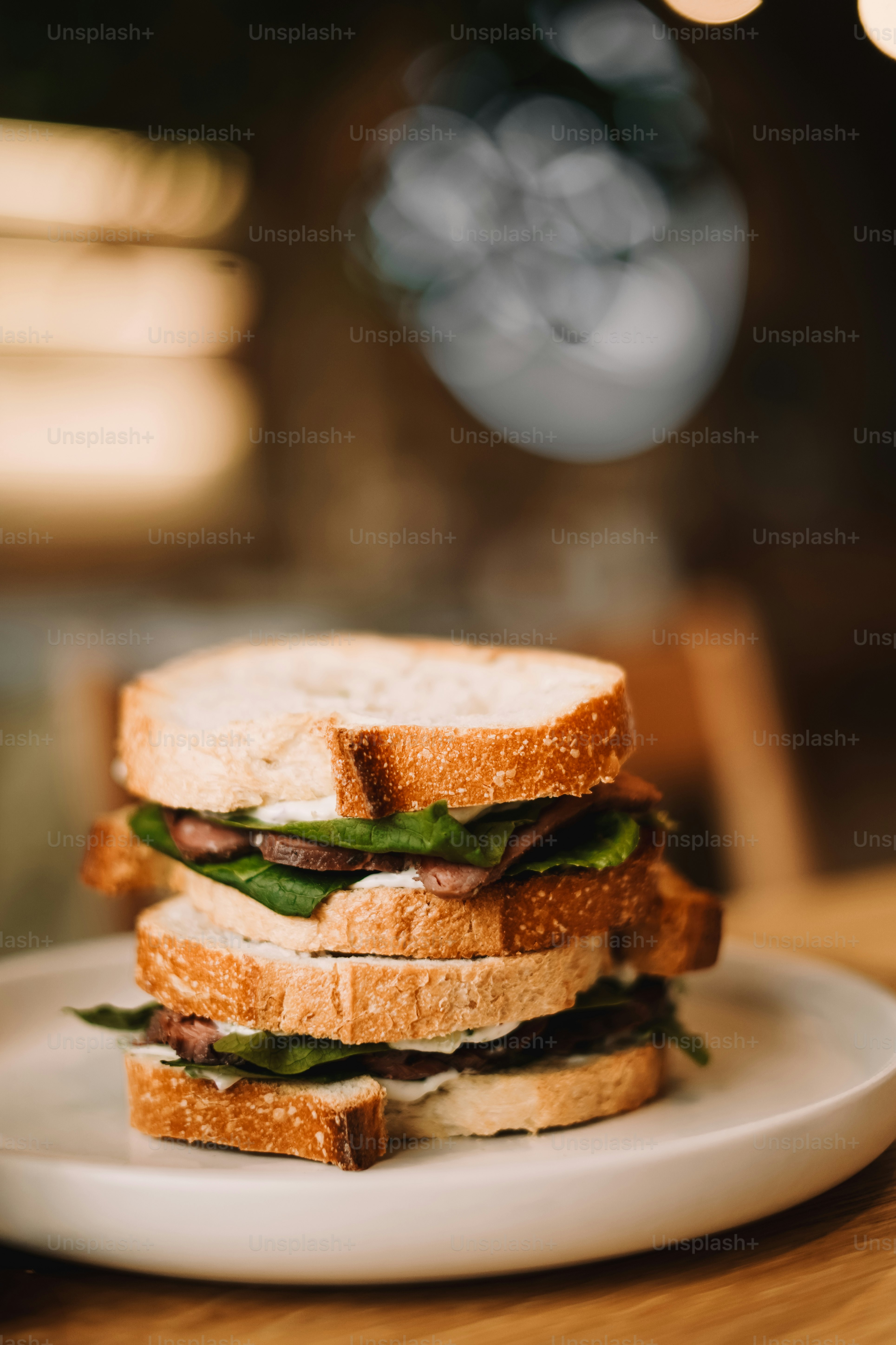 A white plate topped with a sandwich on top of a wooden table photo ...