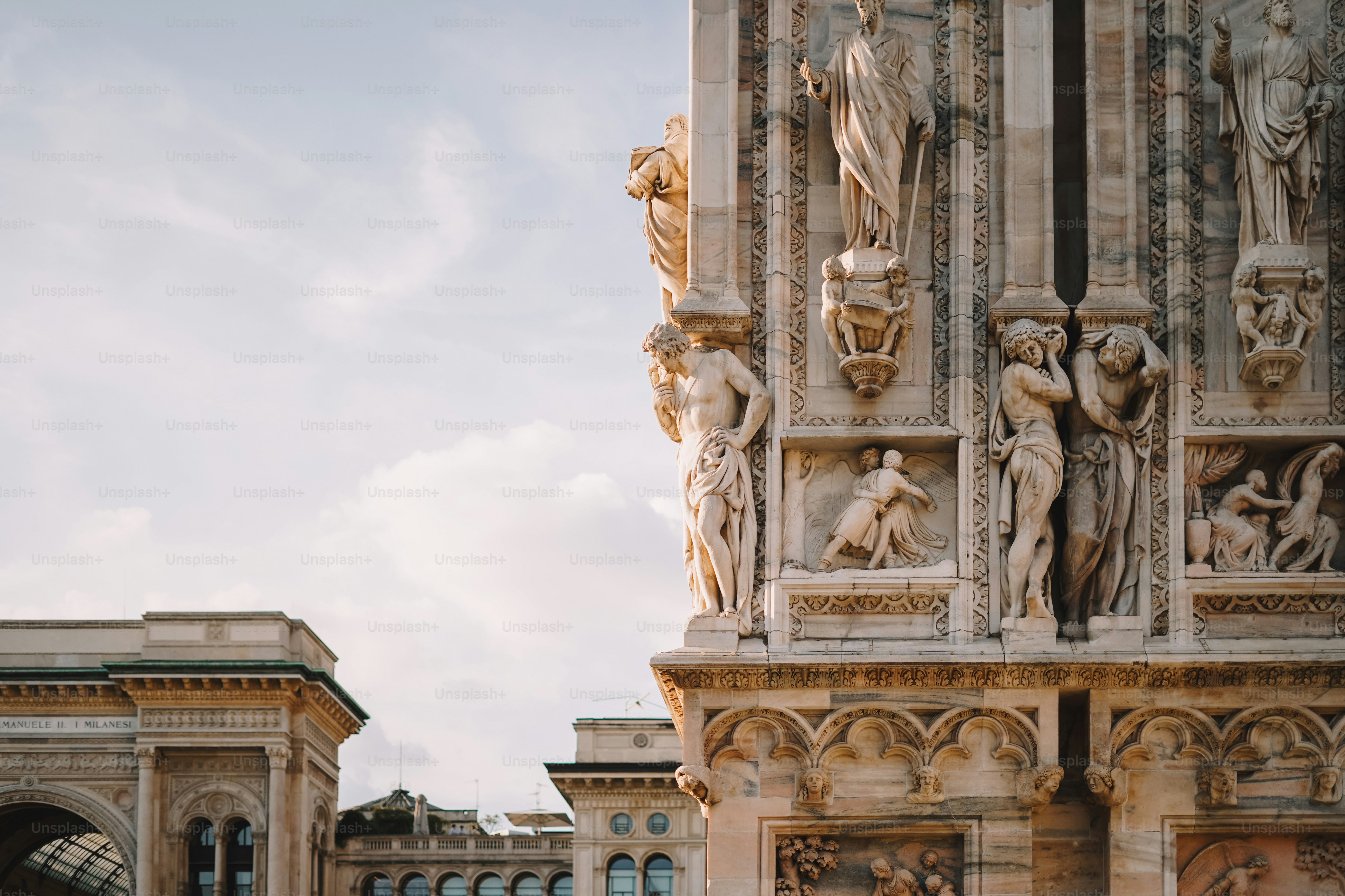 A tall building with statues on the side of it photo – Architecture ...