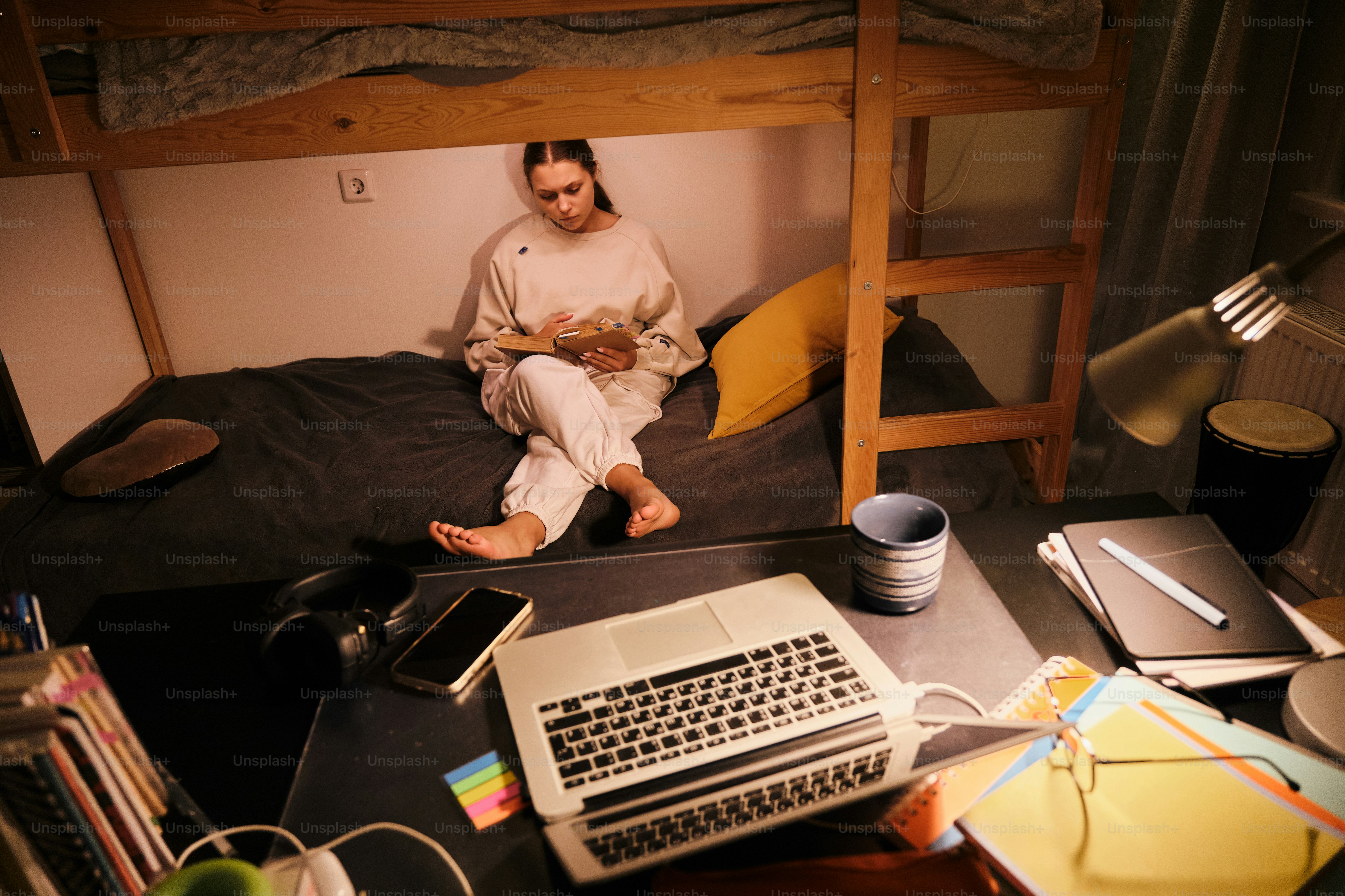 A person sitting on a bed in a room photo – Dorm room Image on Unsplash