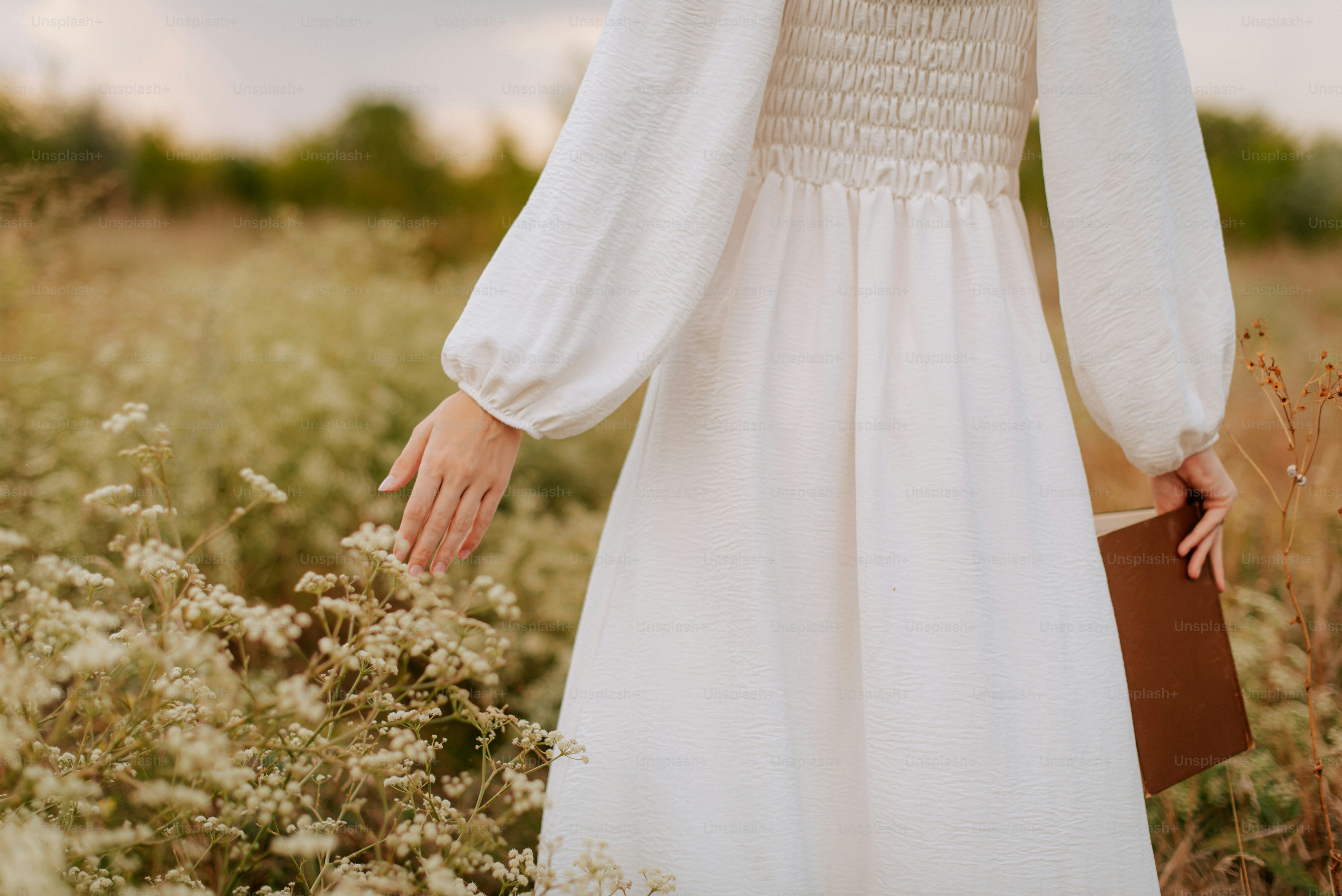 Una mujer con un vestido blanco de pie en un campo foto – Imagen de ...