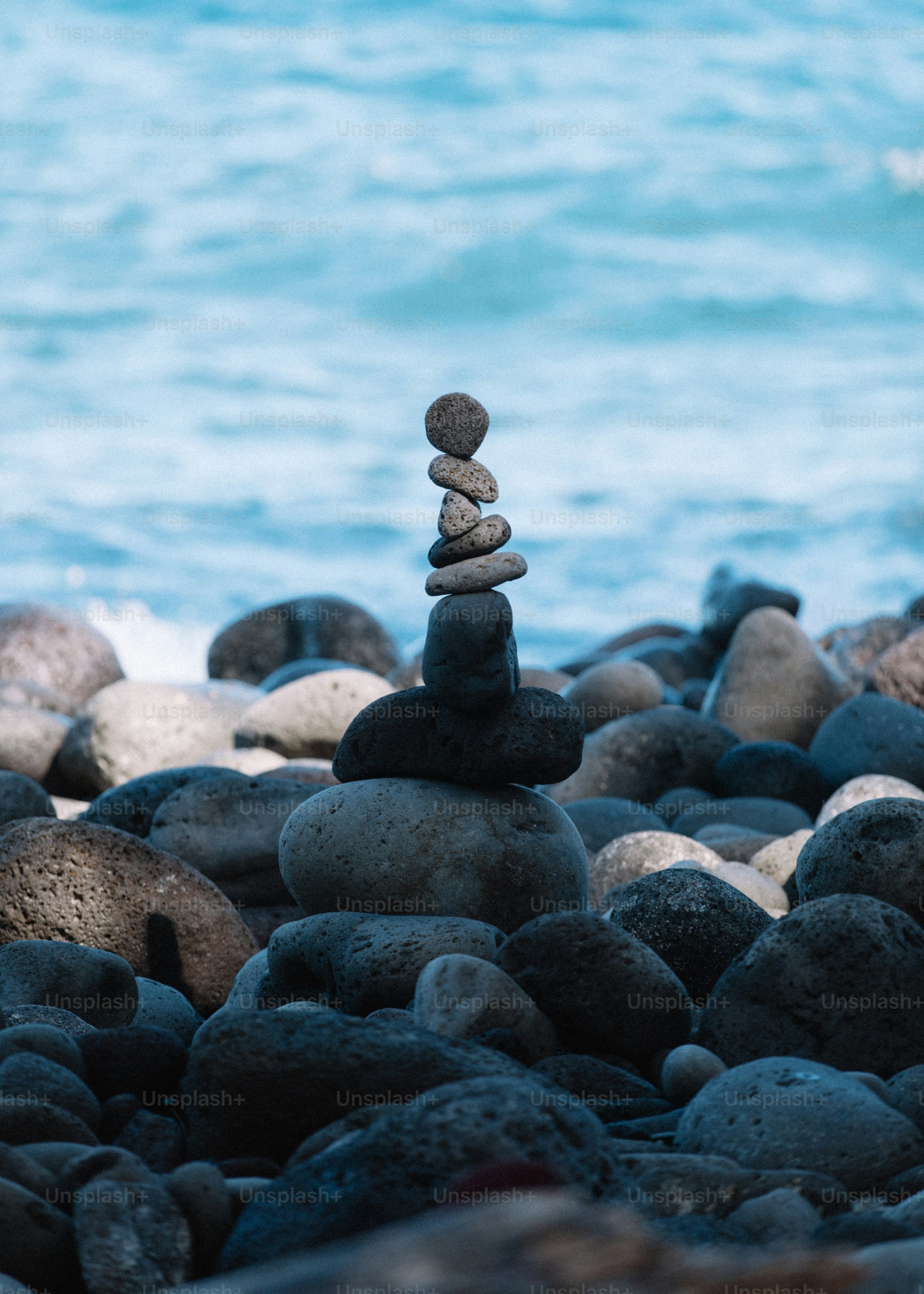 A stack of rocks sitting on top of a beach photo – Stone stack Image on ...