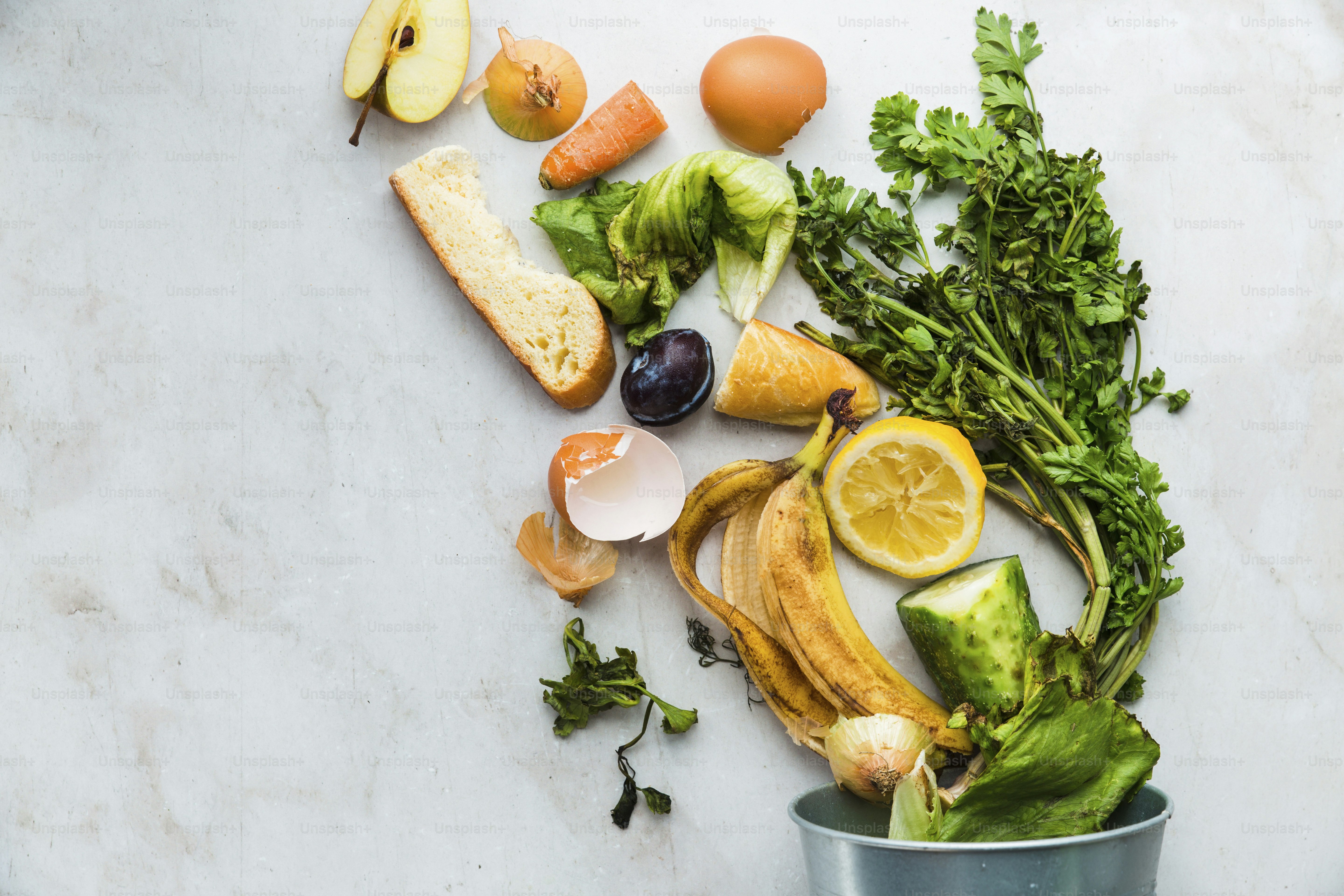 A trash can filled with fruits and vegetables photo – Food waste Image ...