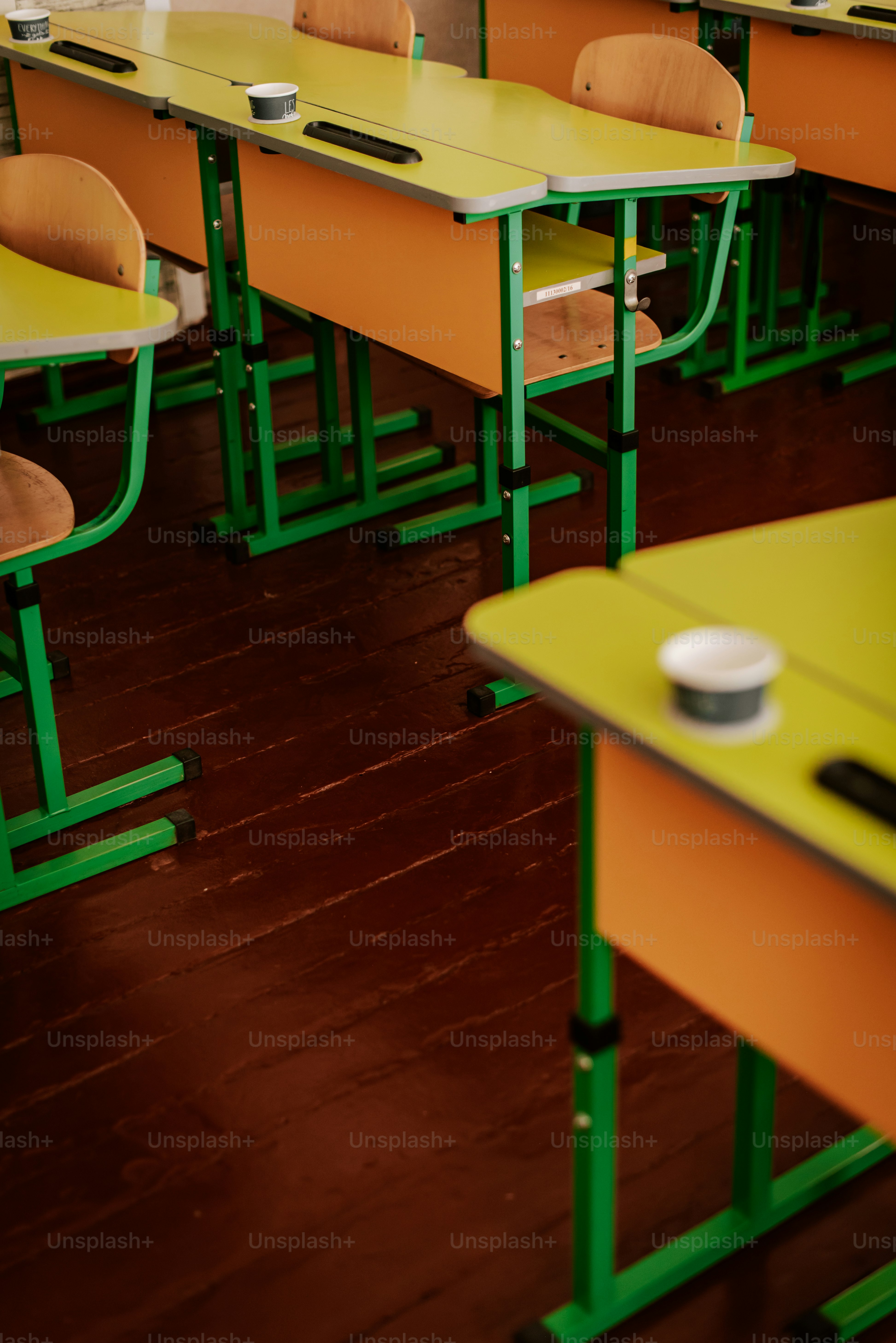 A classroom with desks and chairs and a laptop on the desk photo ...