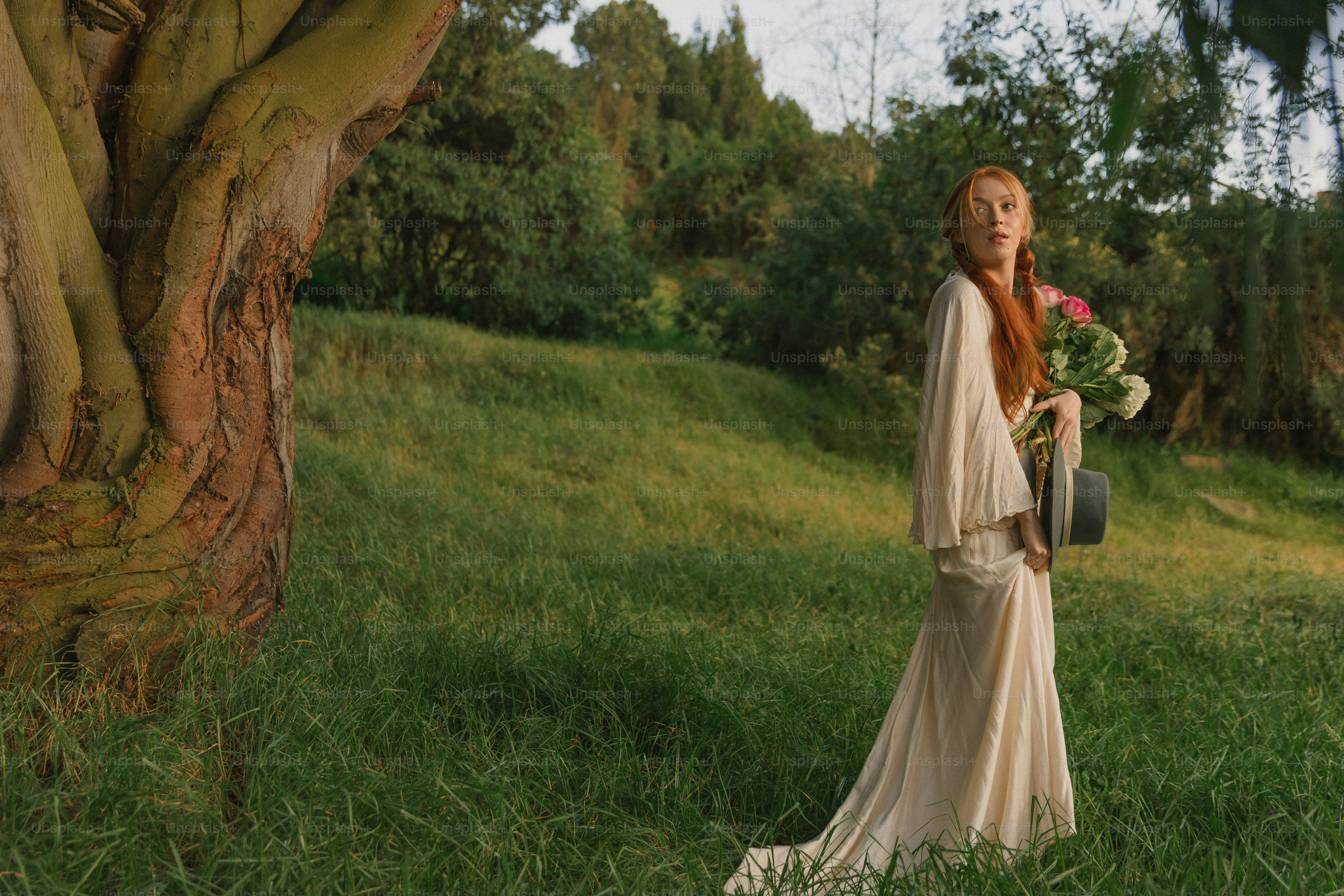 Una mujer con un vestido blanco sosteniendo un ramo de flores foto ...