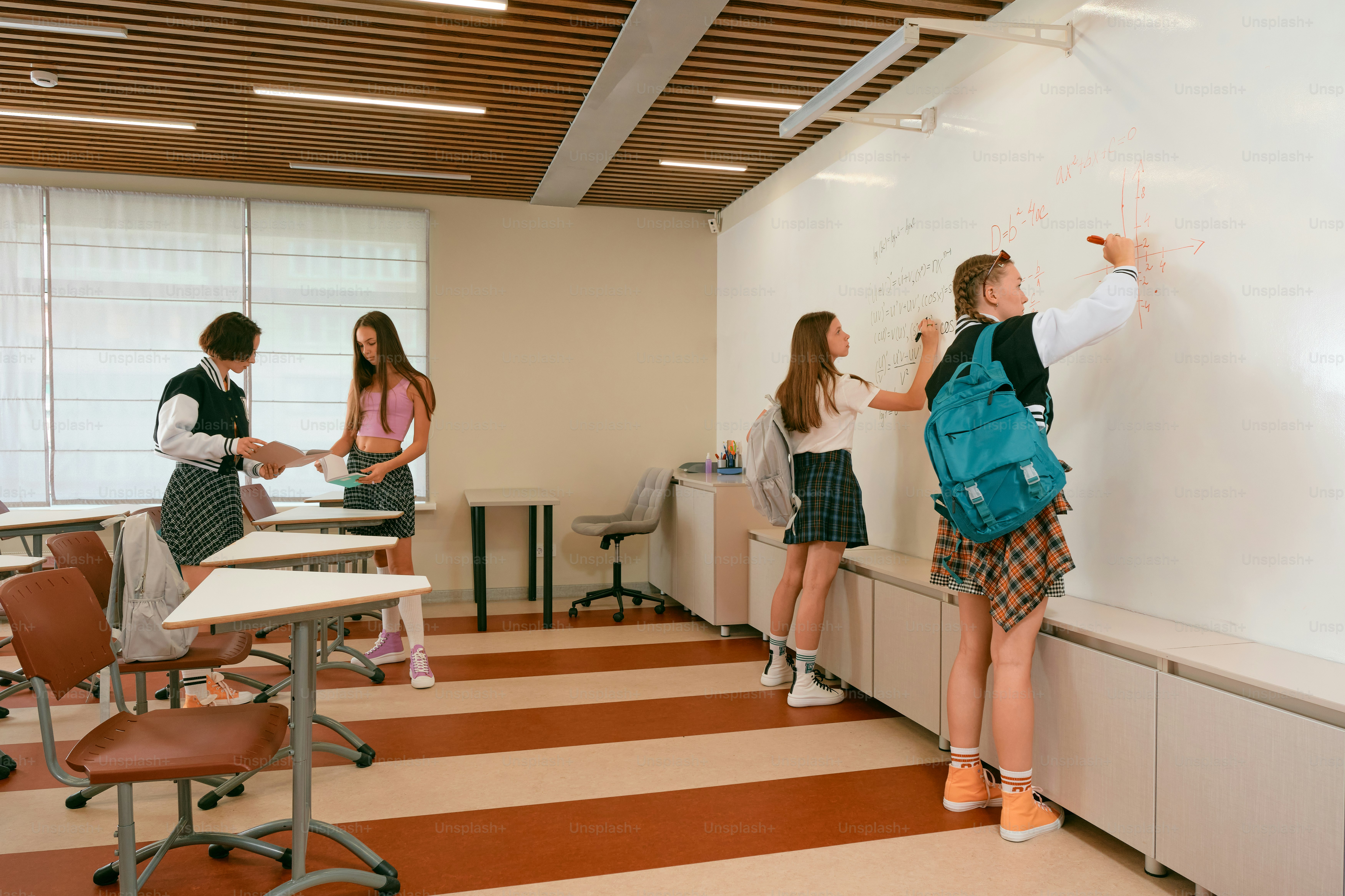 A group of students writing on a whiteboard photo – Classroom fashion ...