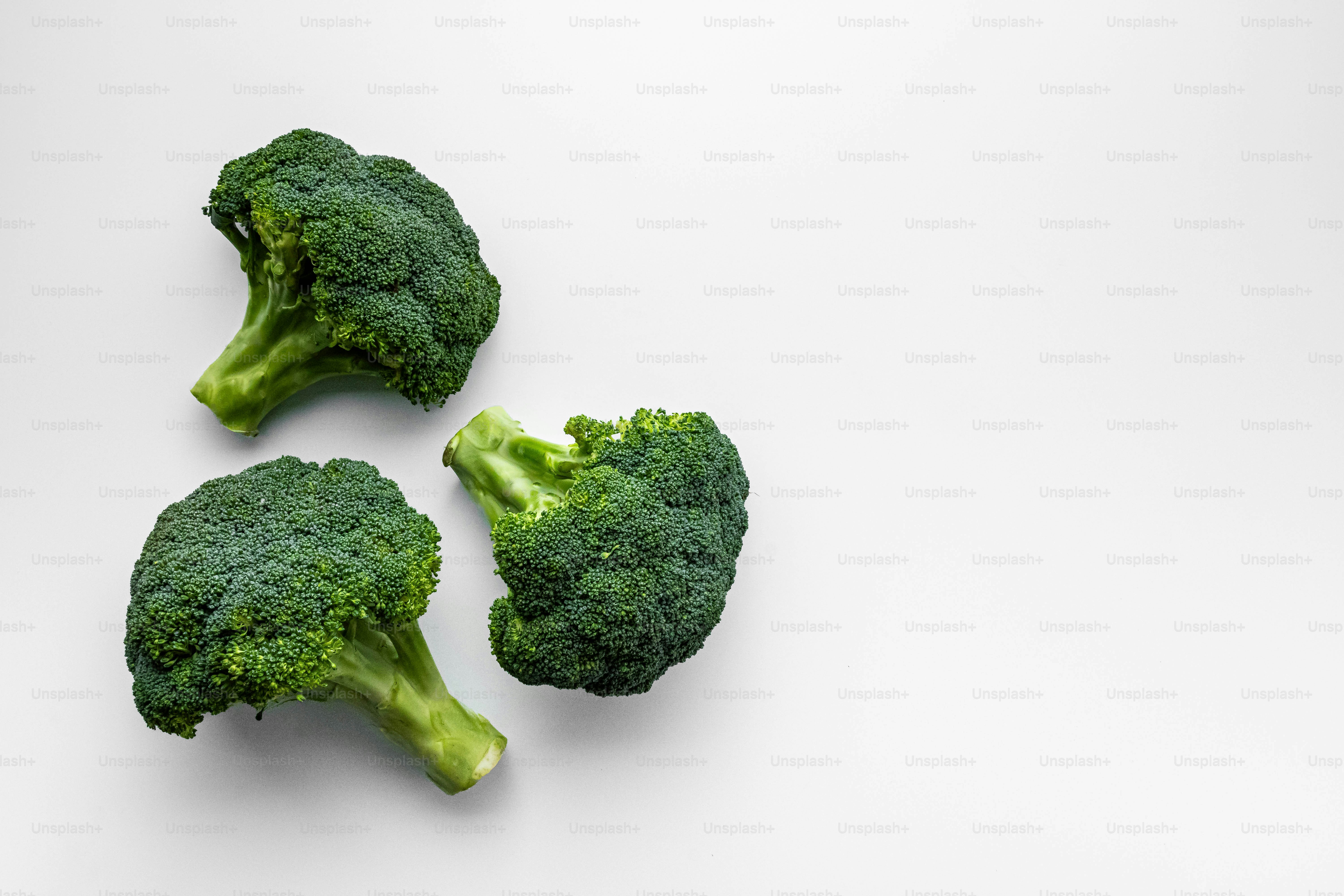 A group of broccoli pieces are arranged in the shape of a triangle ...