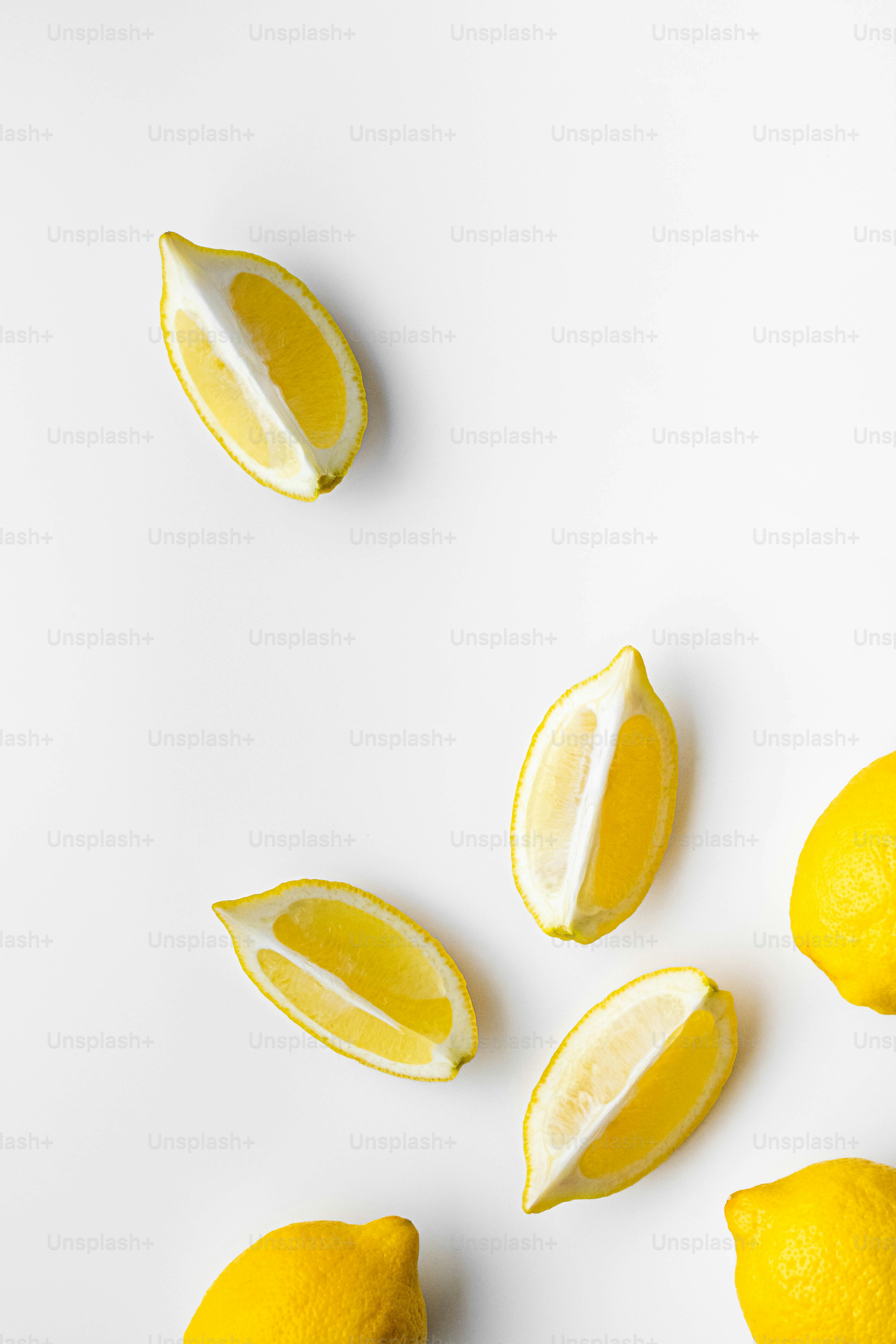 A group of lemons cut in half on a white surface photo – Lemon Image on ...