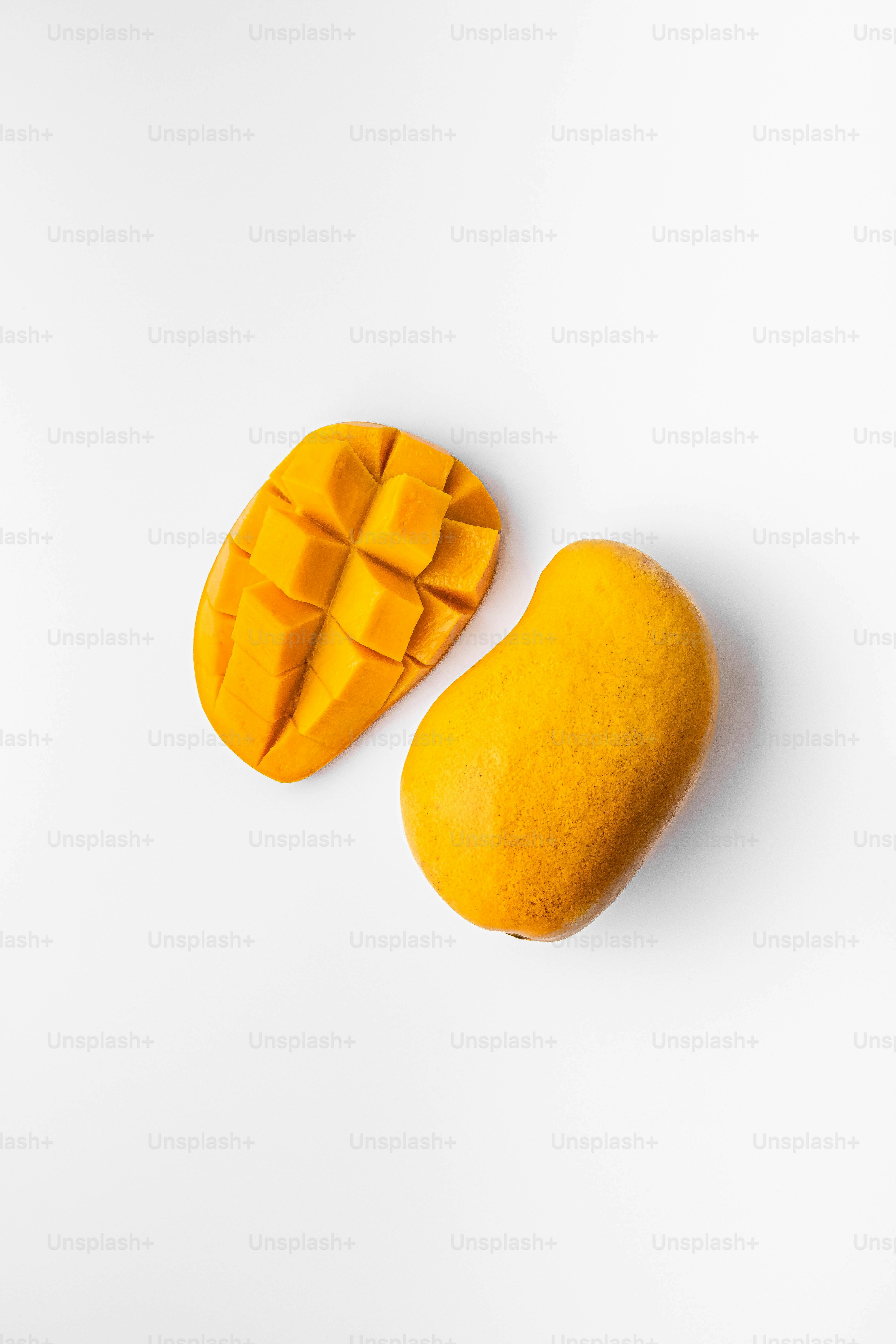 A group of three mangos sitting on top of a white table photo – Mango ...