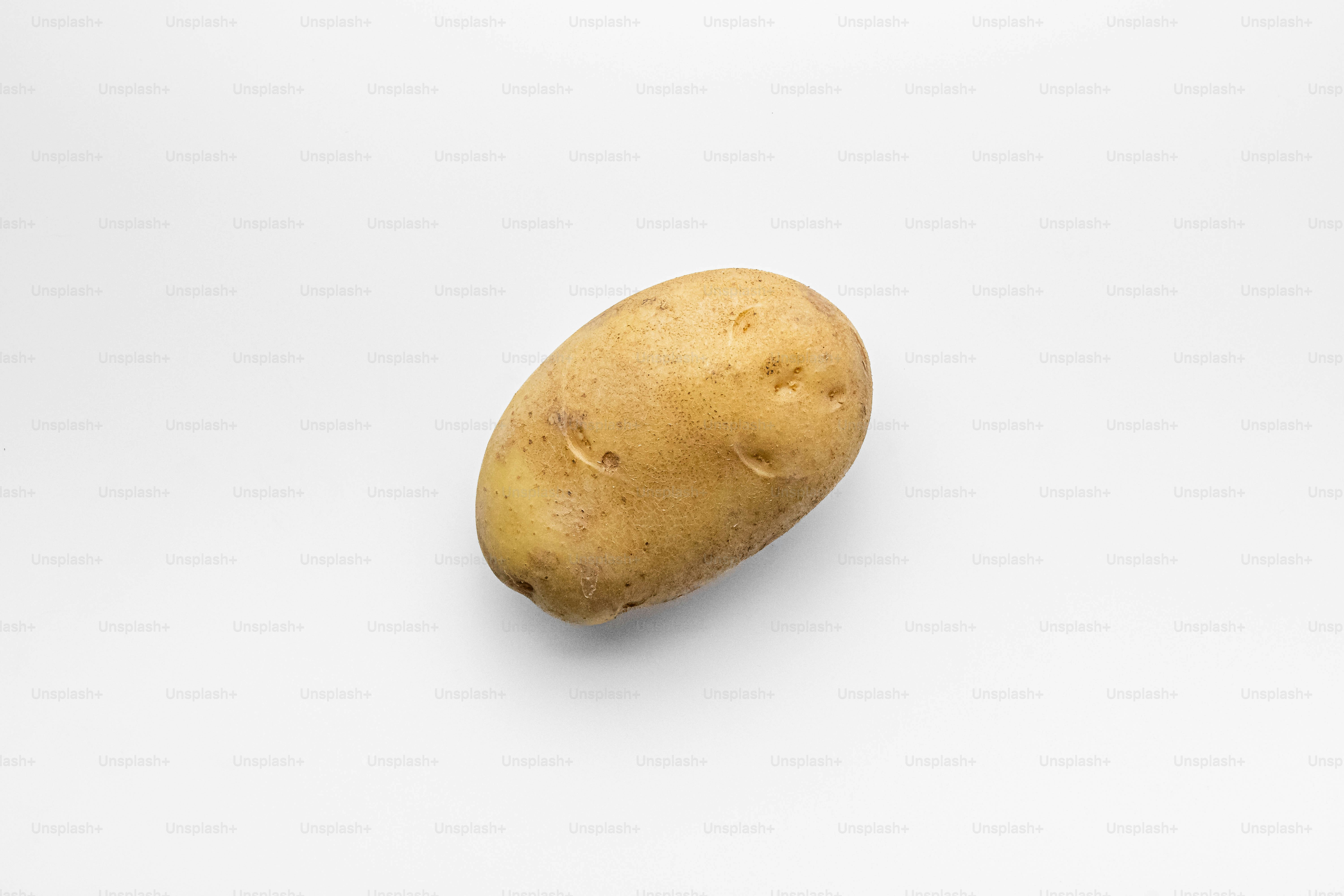 A potato sitting on top of a white table photo – Potato Image on Unsplash
